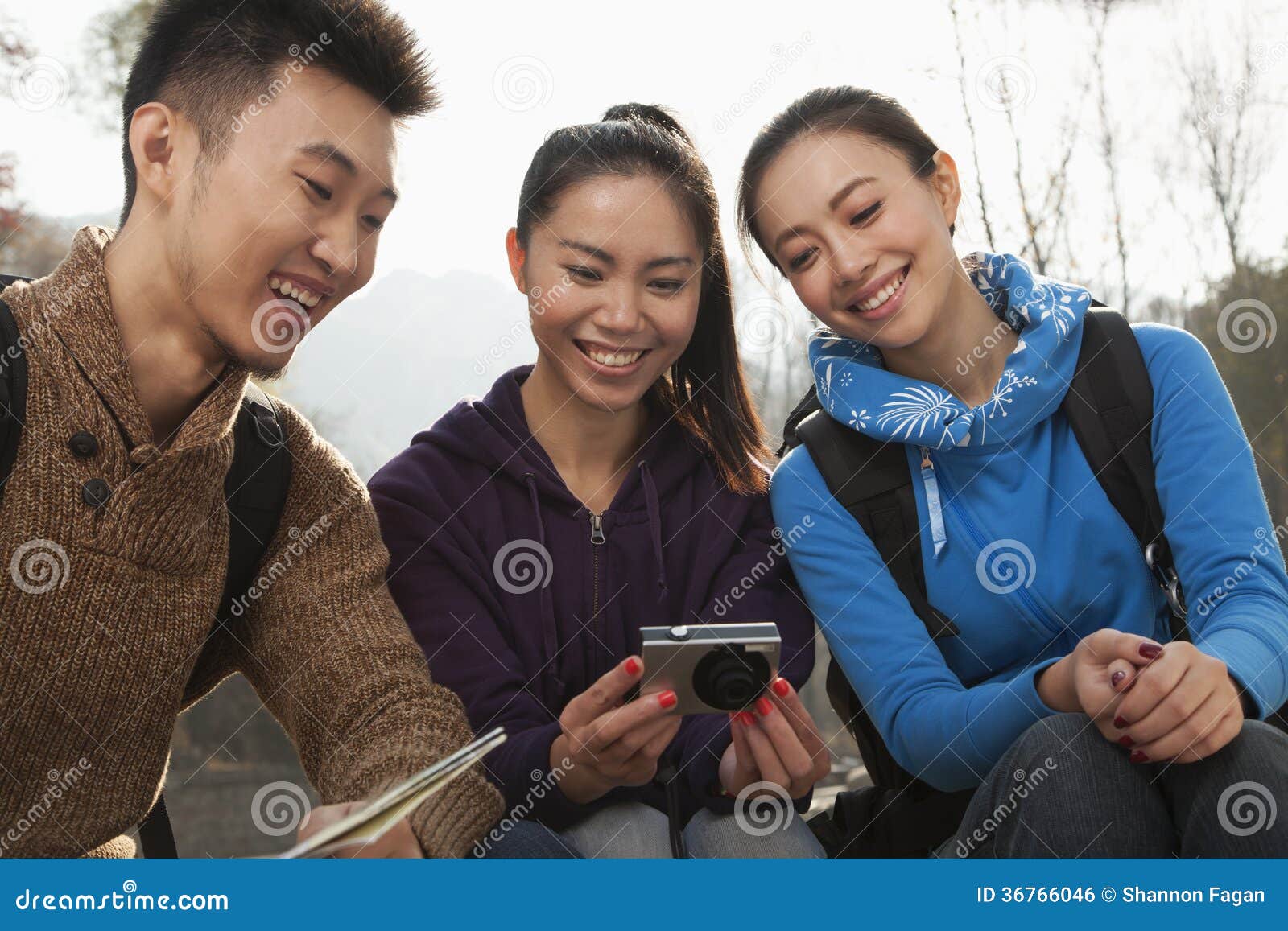 Friends Looking at the Picture on the Screen of Digital Camera Stock ...