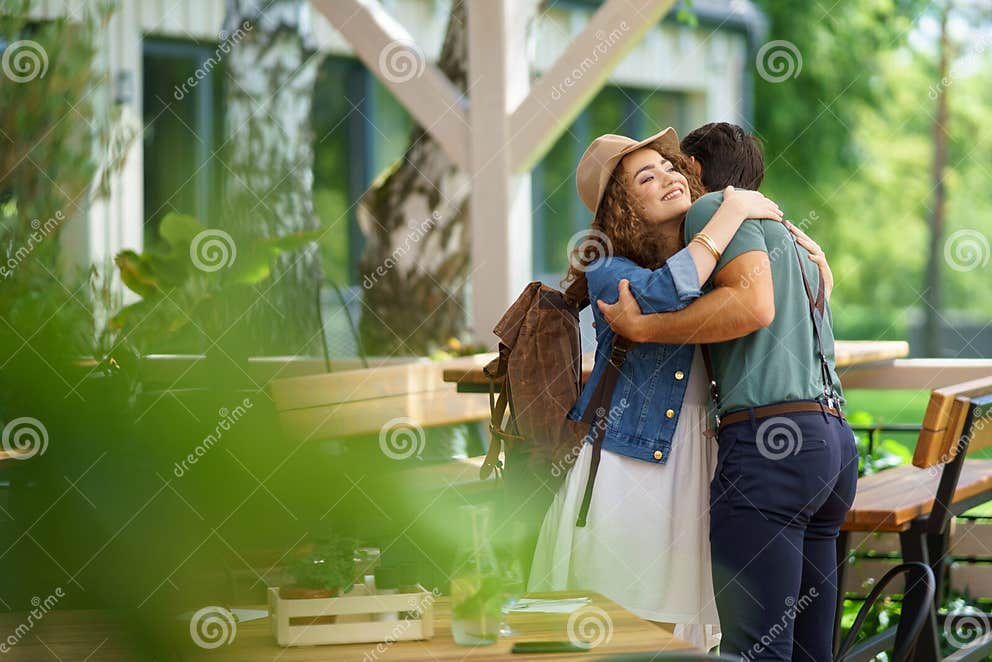 Friends Meeting At A Restaurant Terrace Greeting Hugging After Long