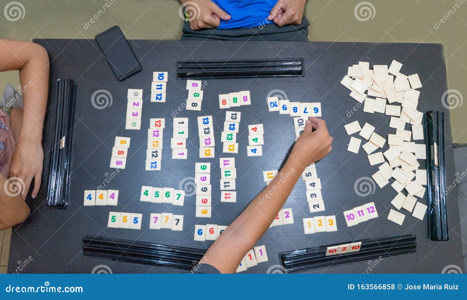 Friends Playing To a Strategy Game Board on a Table. Blocks of Number ...