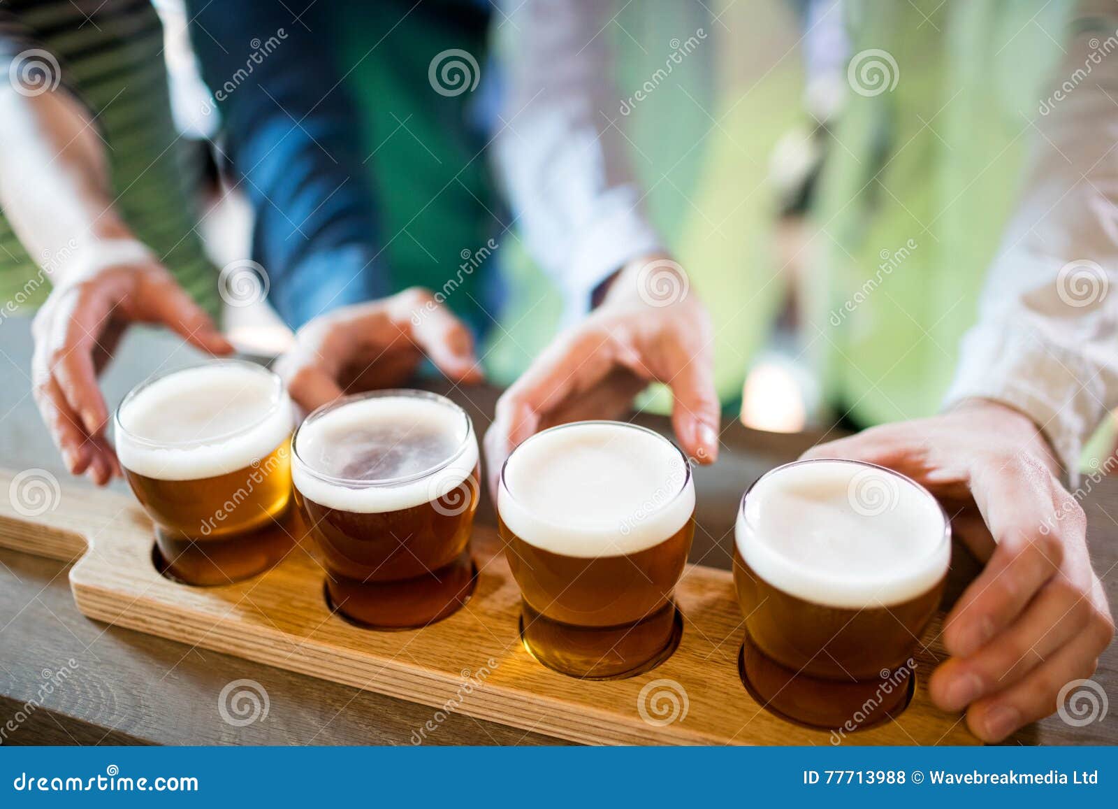 Friends Reaching Towards Beer Sampler on Counter Stock Photo - Image of ...