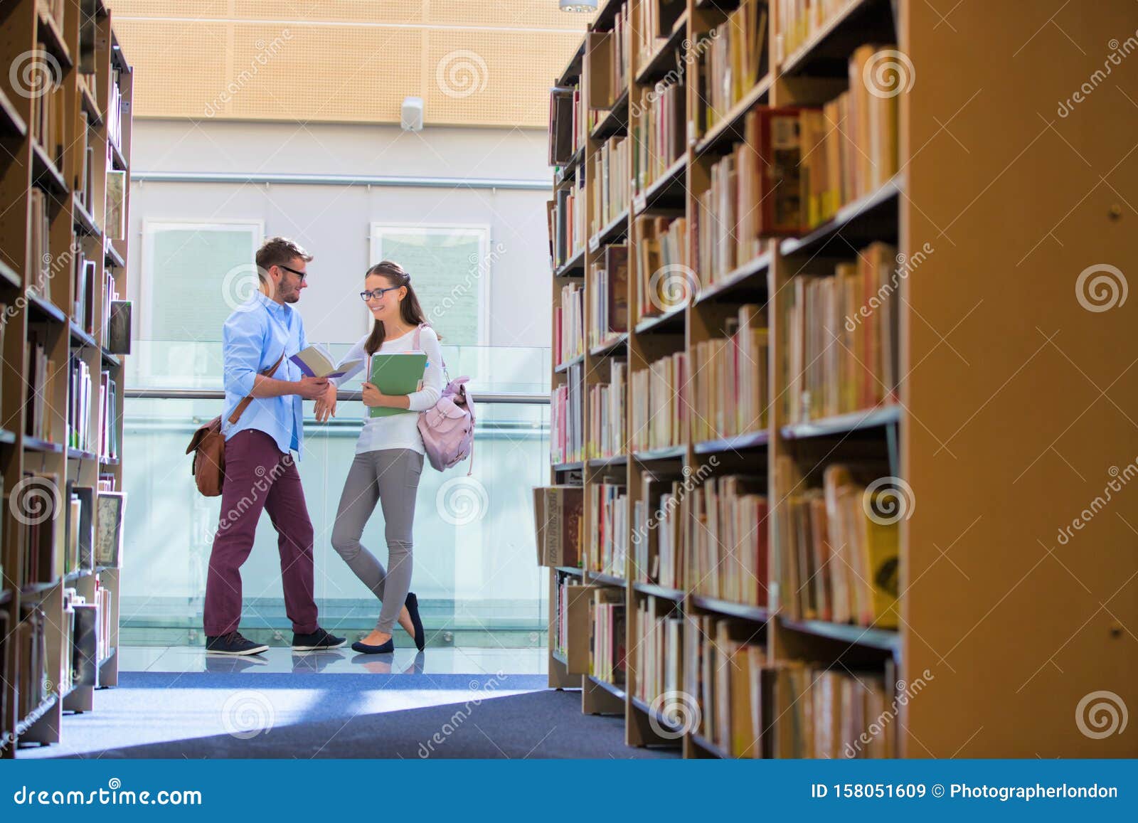Friends Reading Books while Discussing at Library in University Stock ... Friends Reading Books while Discussing at Library in University Stock ...