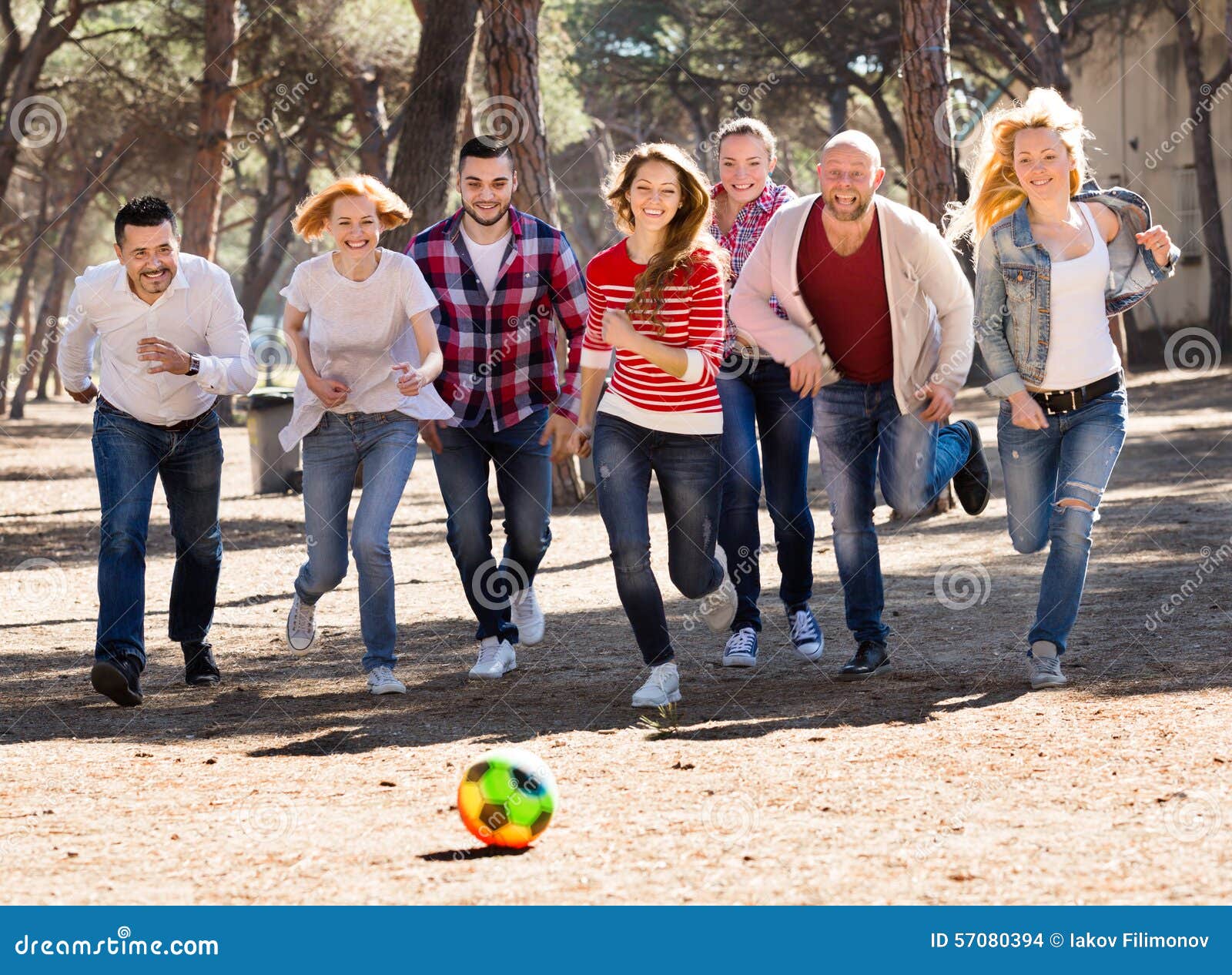 Friends running with ball stock photo. Image of pass - 57080394