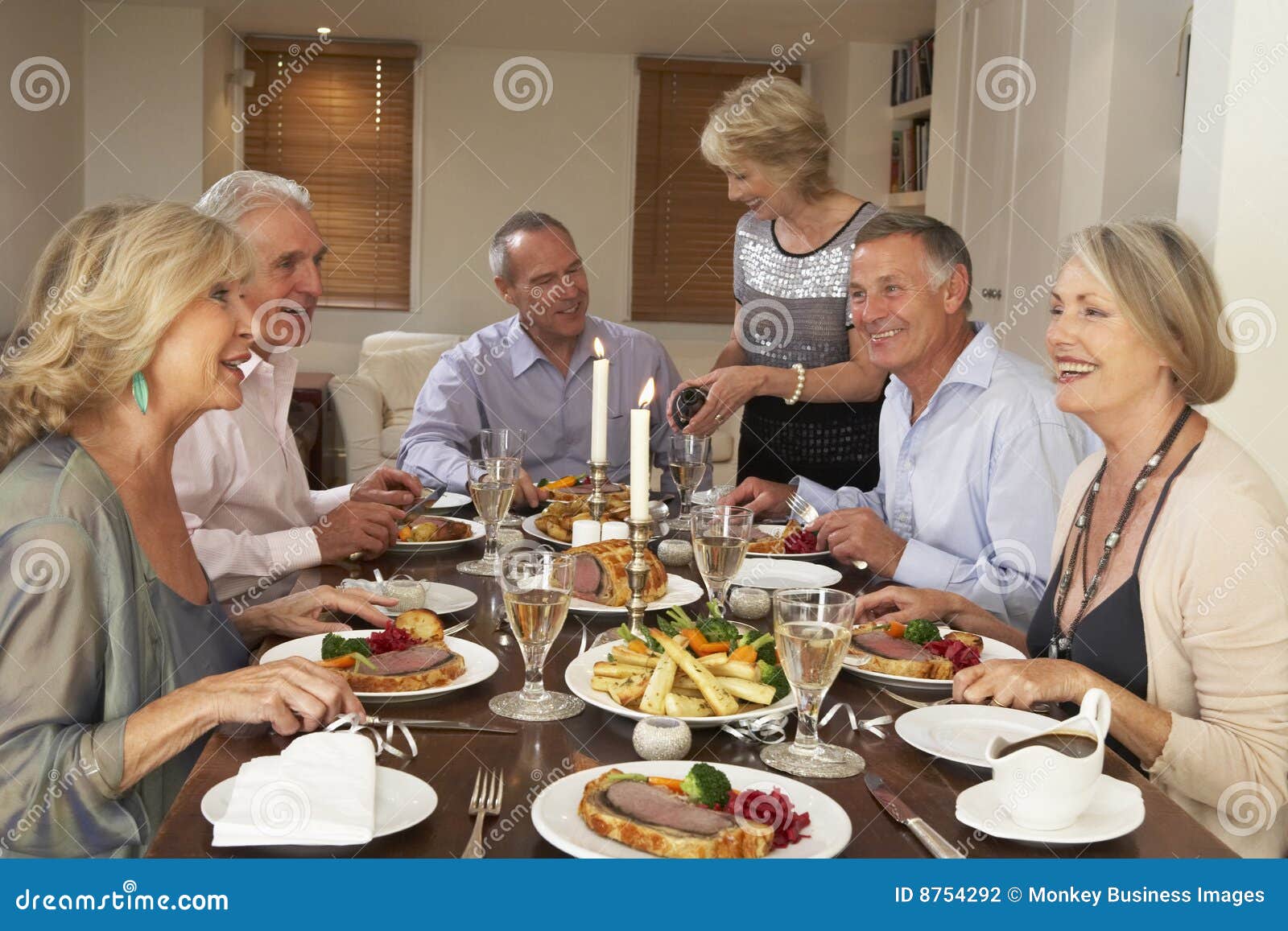 Friends Seated at Table for a Dinner Party Stock Photo - Image of host ...