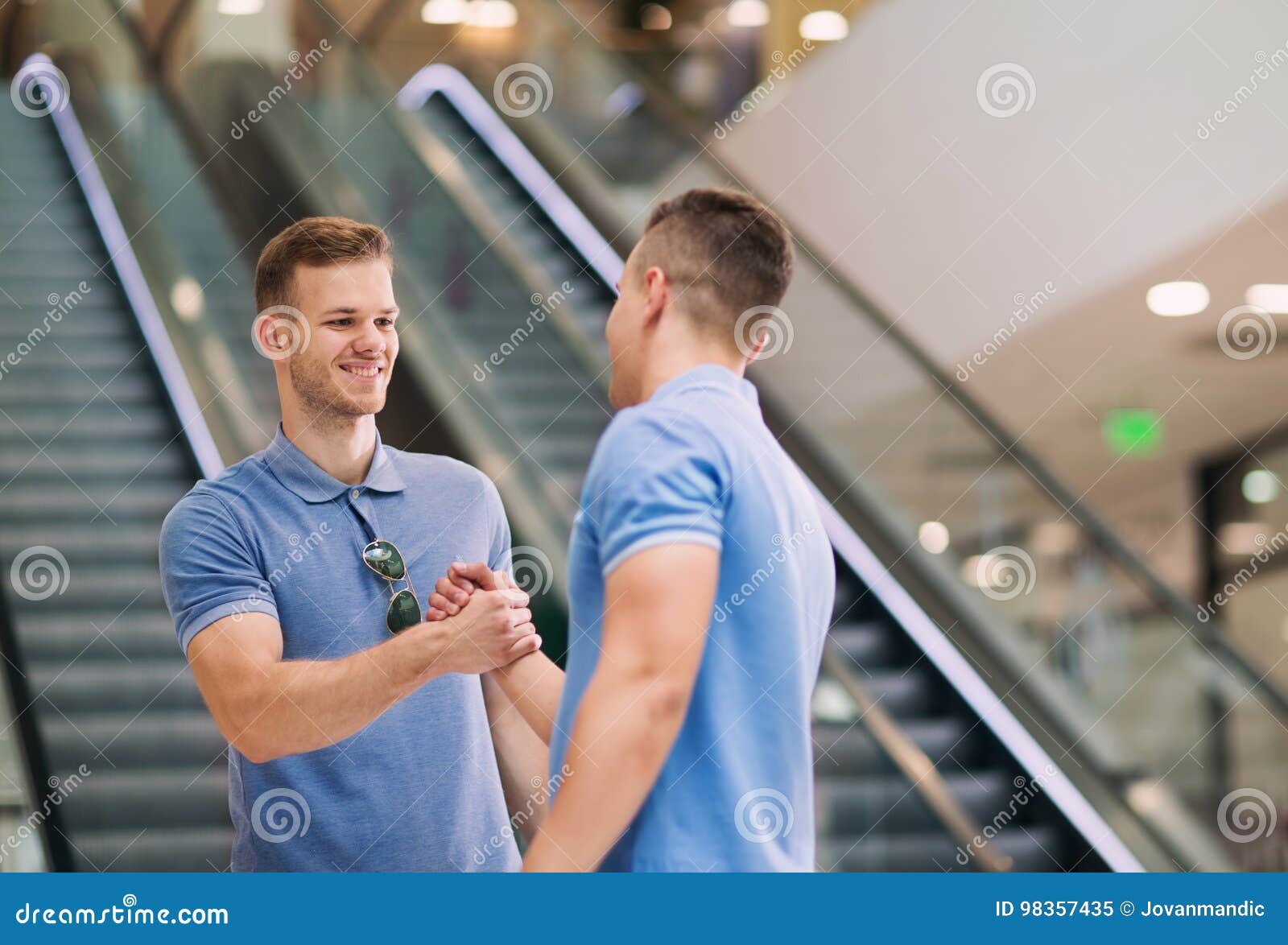 Friends Shaking Hands in a Shopping Mall Stock Image - Image of ...