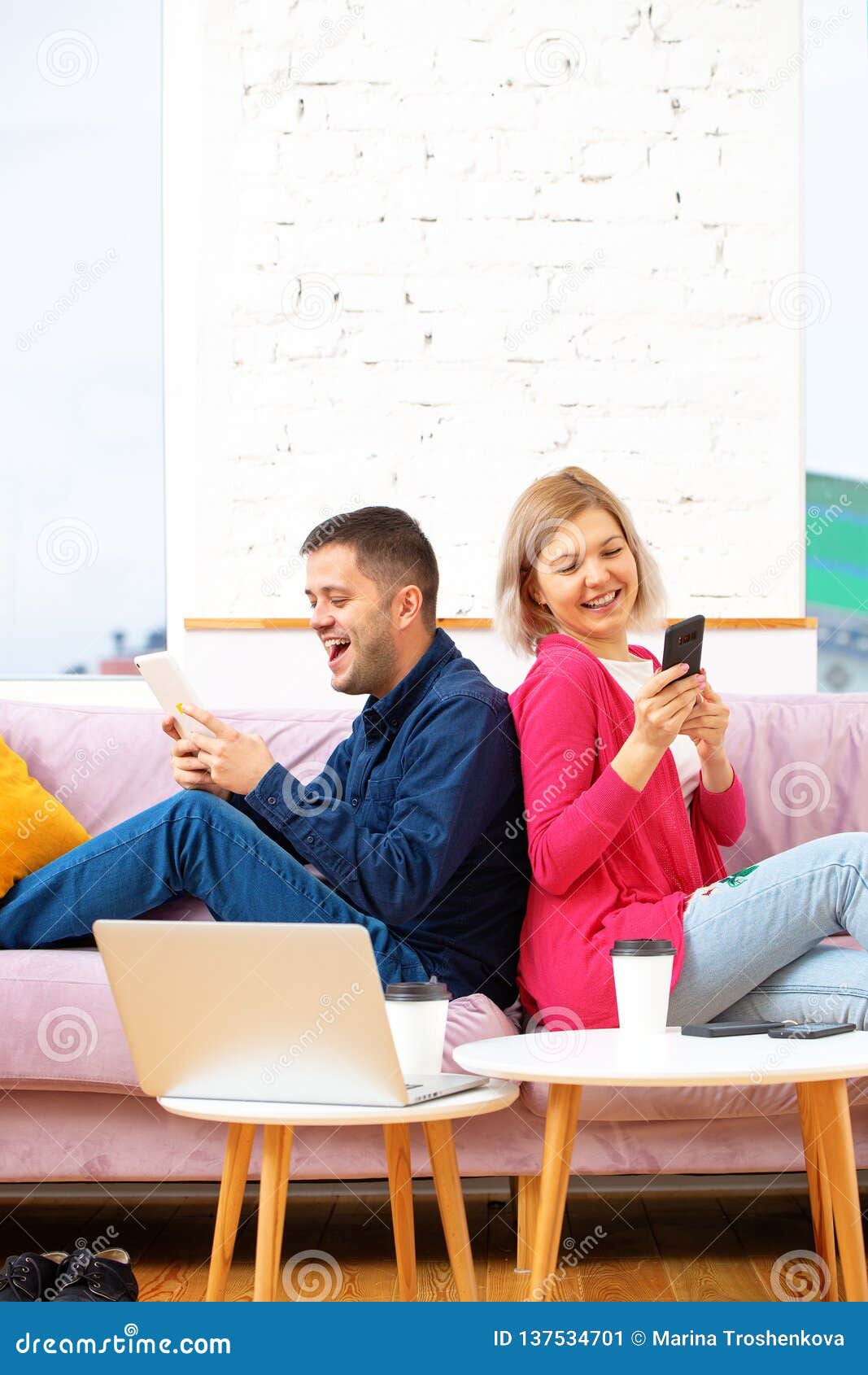 Friends Sit on the Couch, Chatting and Using a Smartphone, Desktop ...