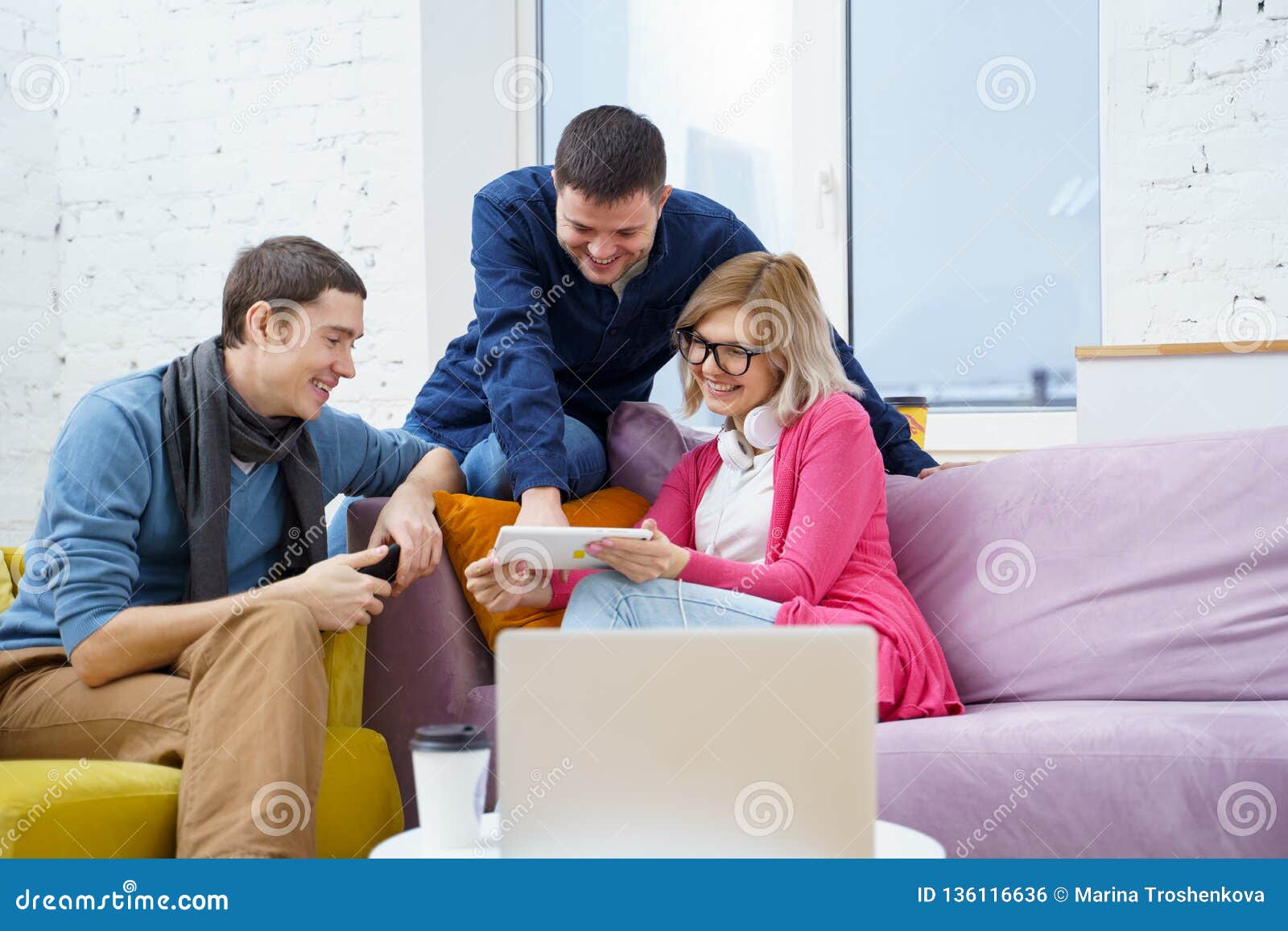 Friends Sit on the Couch, Chatting and Using a Smartphone, Desktop ...