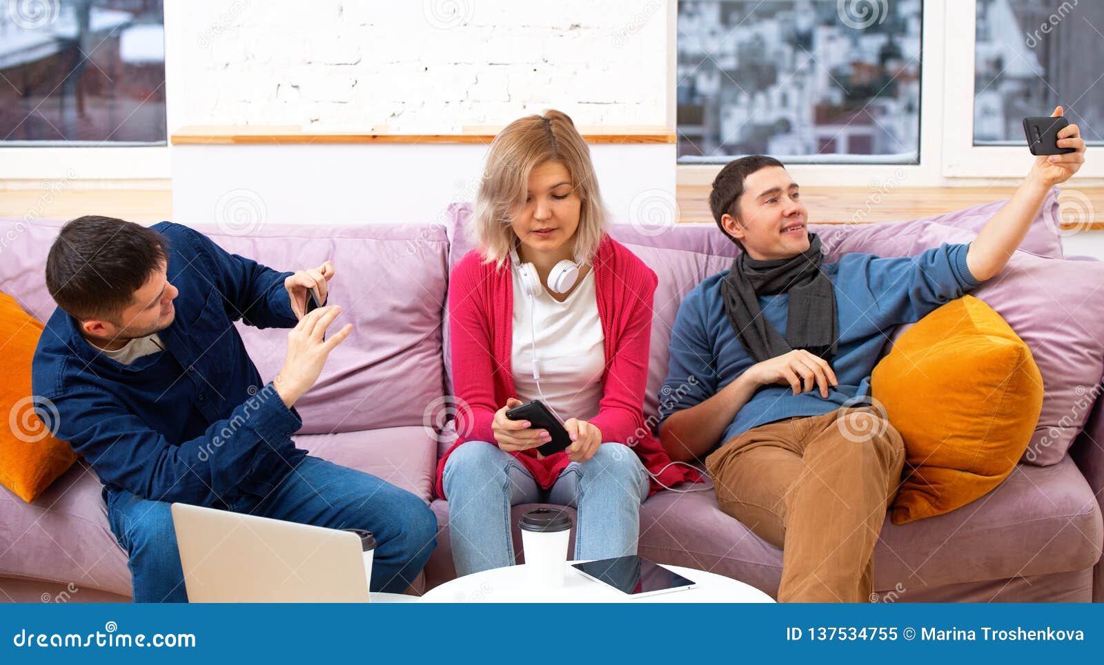 Friends Sit on the Couch, Chatting and Using a Smartphone, Desktop ...