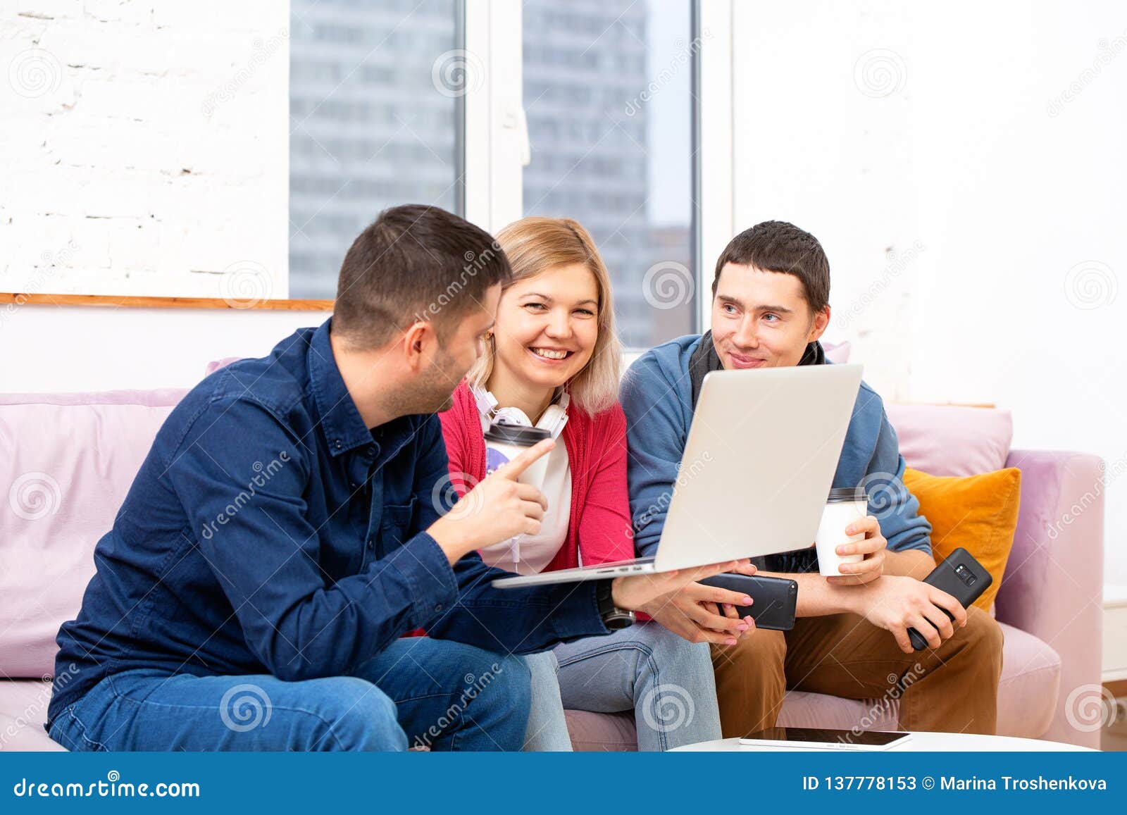 Friends Sit on the Couch, Chatting and Using a Smartphone, Desktop ...