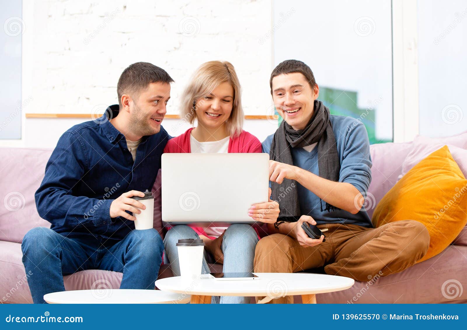 Friends Sit on the Couch, Chatting and Using a Smartphone, Desktop ...