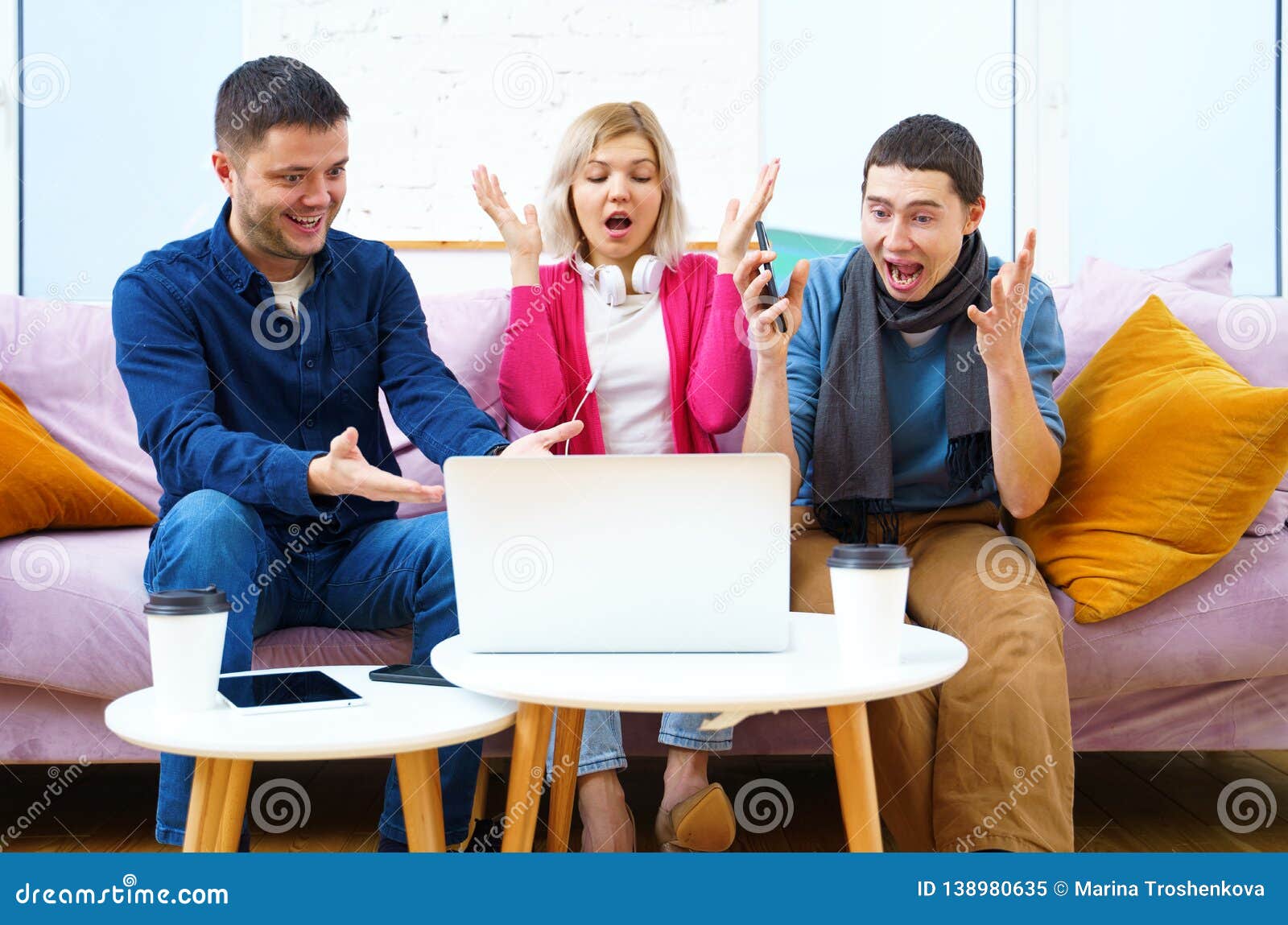 Friends Sit on the Couch, Chatting and Using a Smartphone, Desktop ...