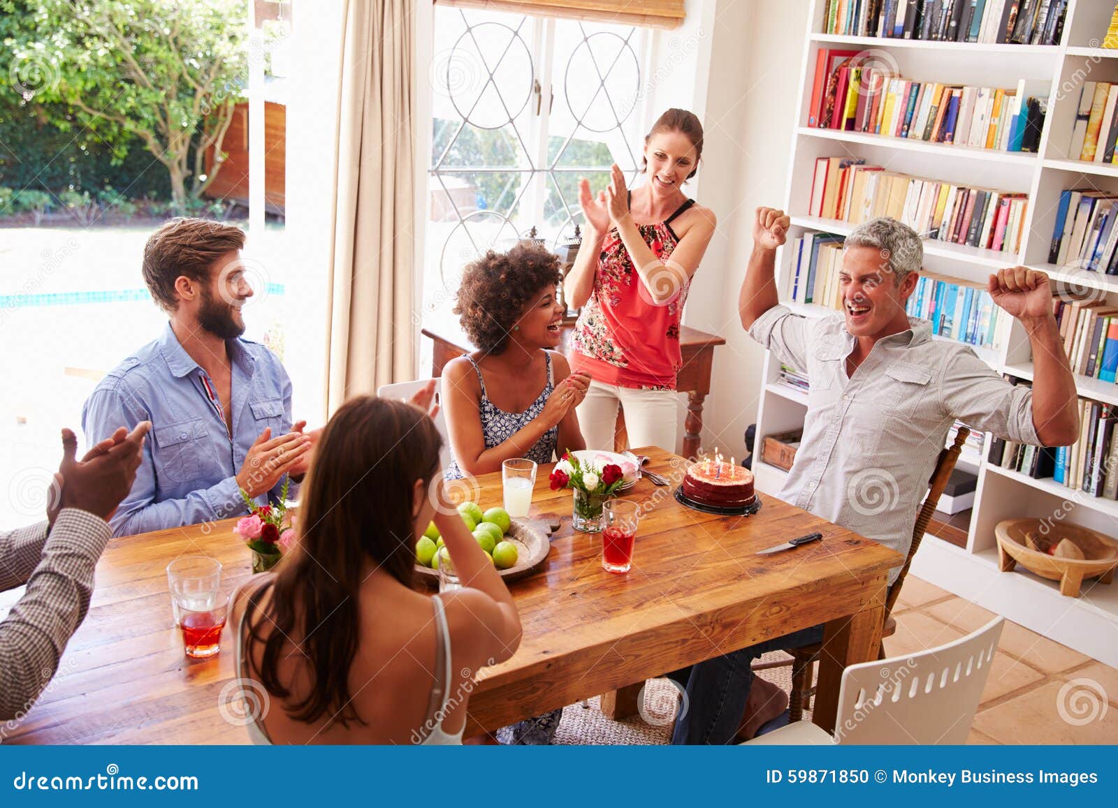 Friends Sitting at a Dining Table Celebrating a Birthday Stock Photo ...