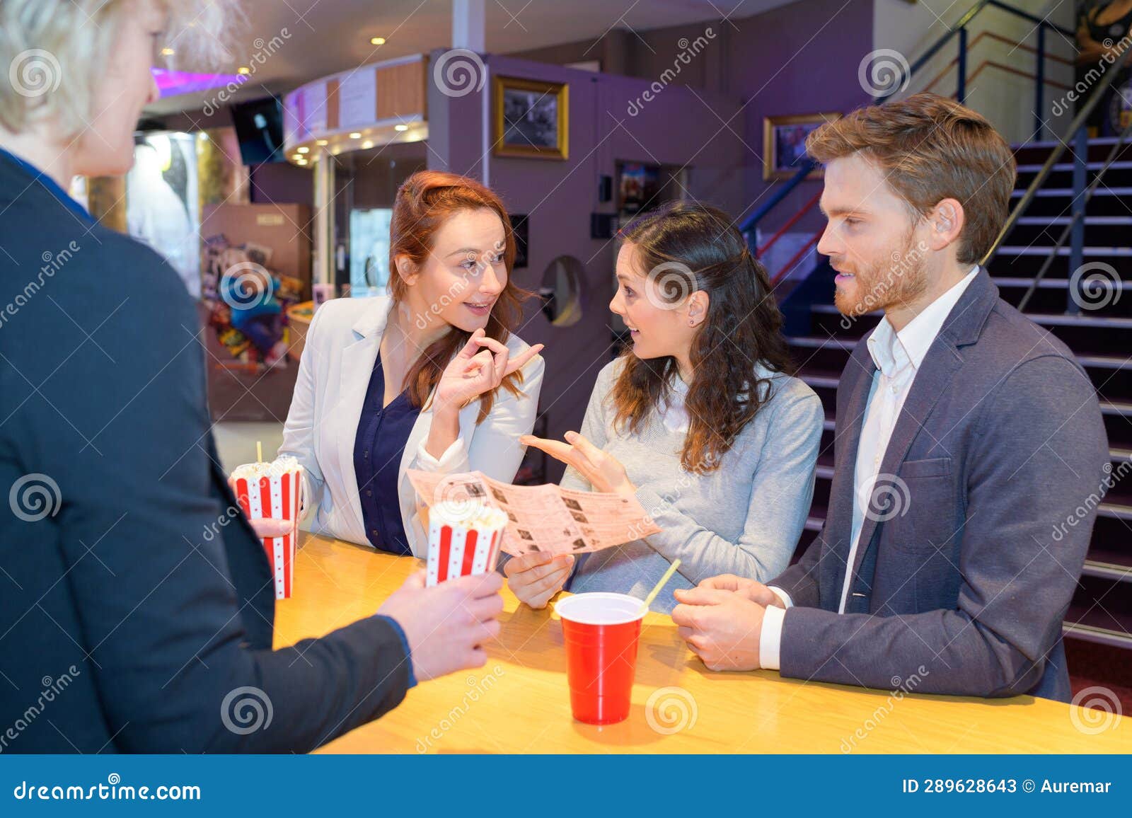 Friends Socializing in Cinema Lobby Lounge Stock Image - Image of ...