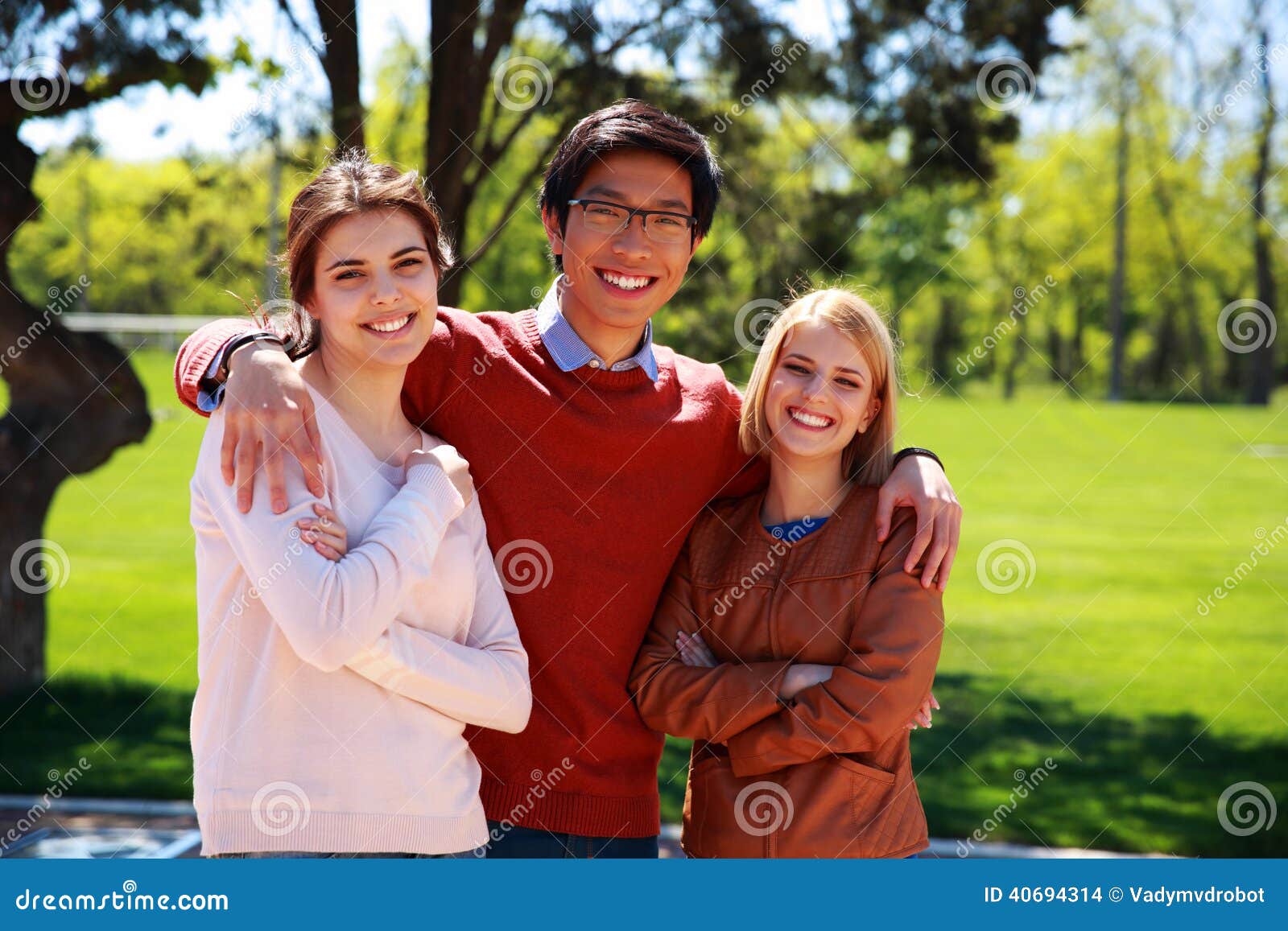 Friends standing in park stock photo. Image of playful - 40694314