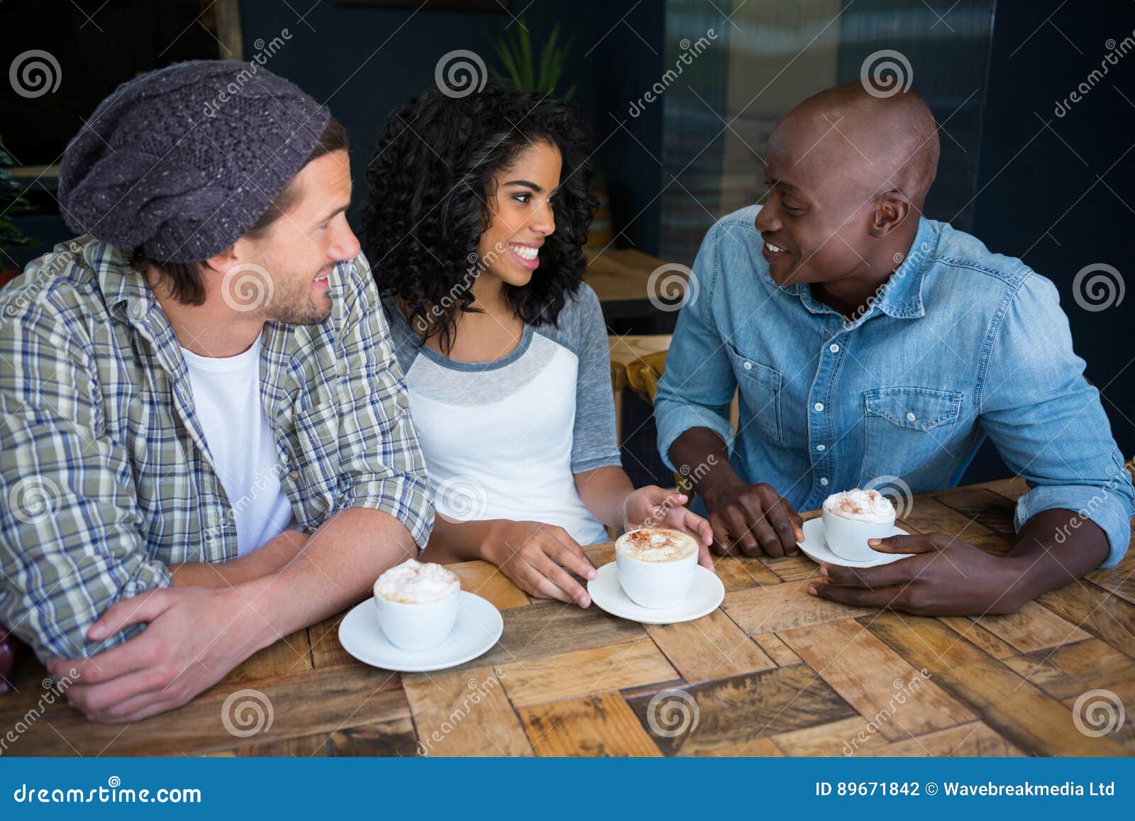 Friends Talking while Having Coffee at Table in Coffee Shop Stock Photo ...