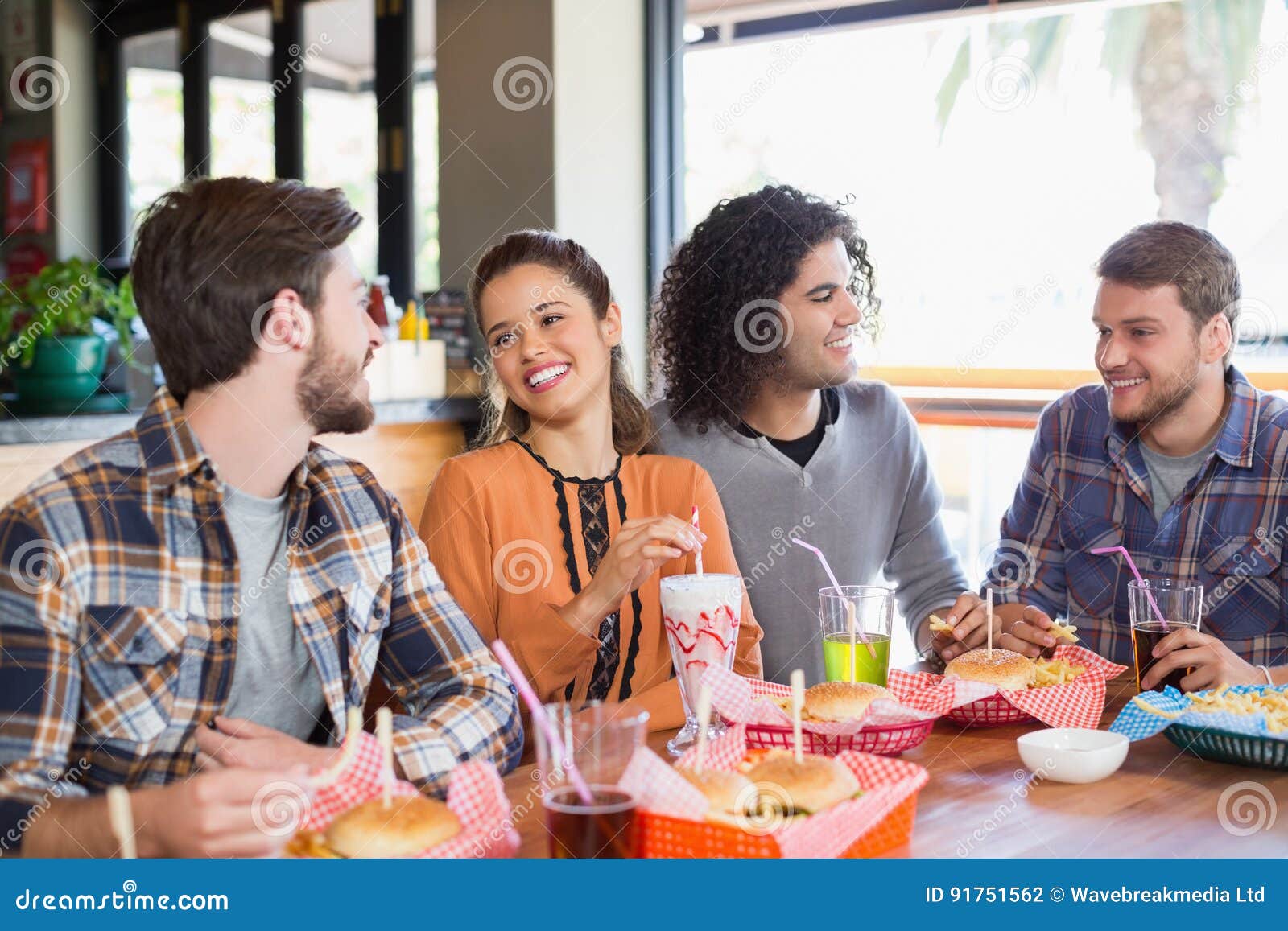 Friends Talking while Having Lunch in Restaurant Stock Photo - Image of ...