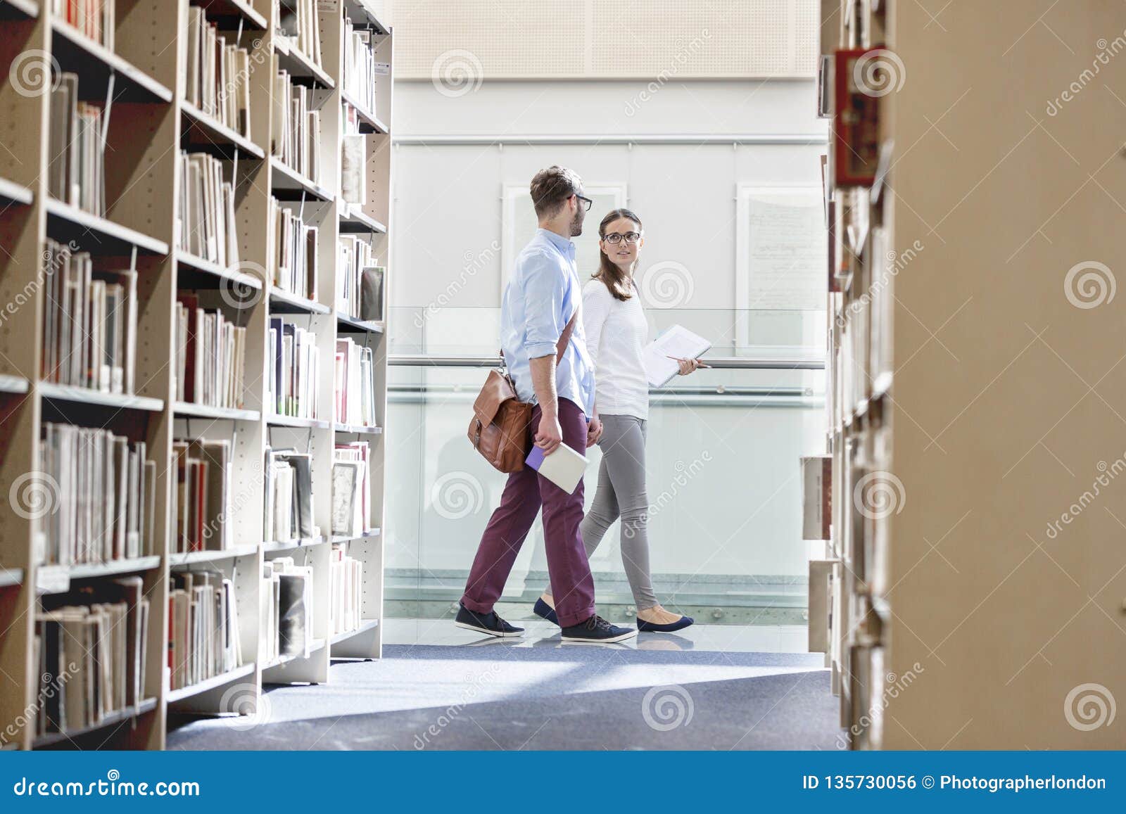 Friends Talking while Walking in University Library Stock Photo - Image ...