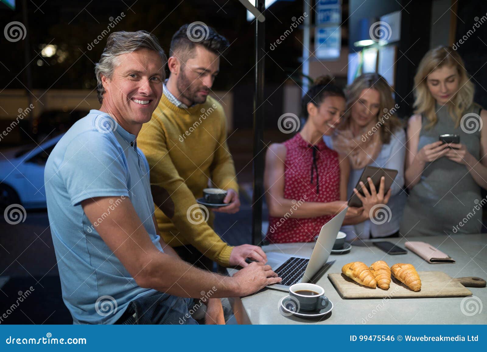 Friends Using Electronic Gadgets while Having Coffee Stock Photo ...