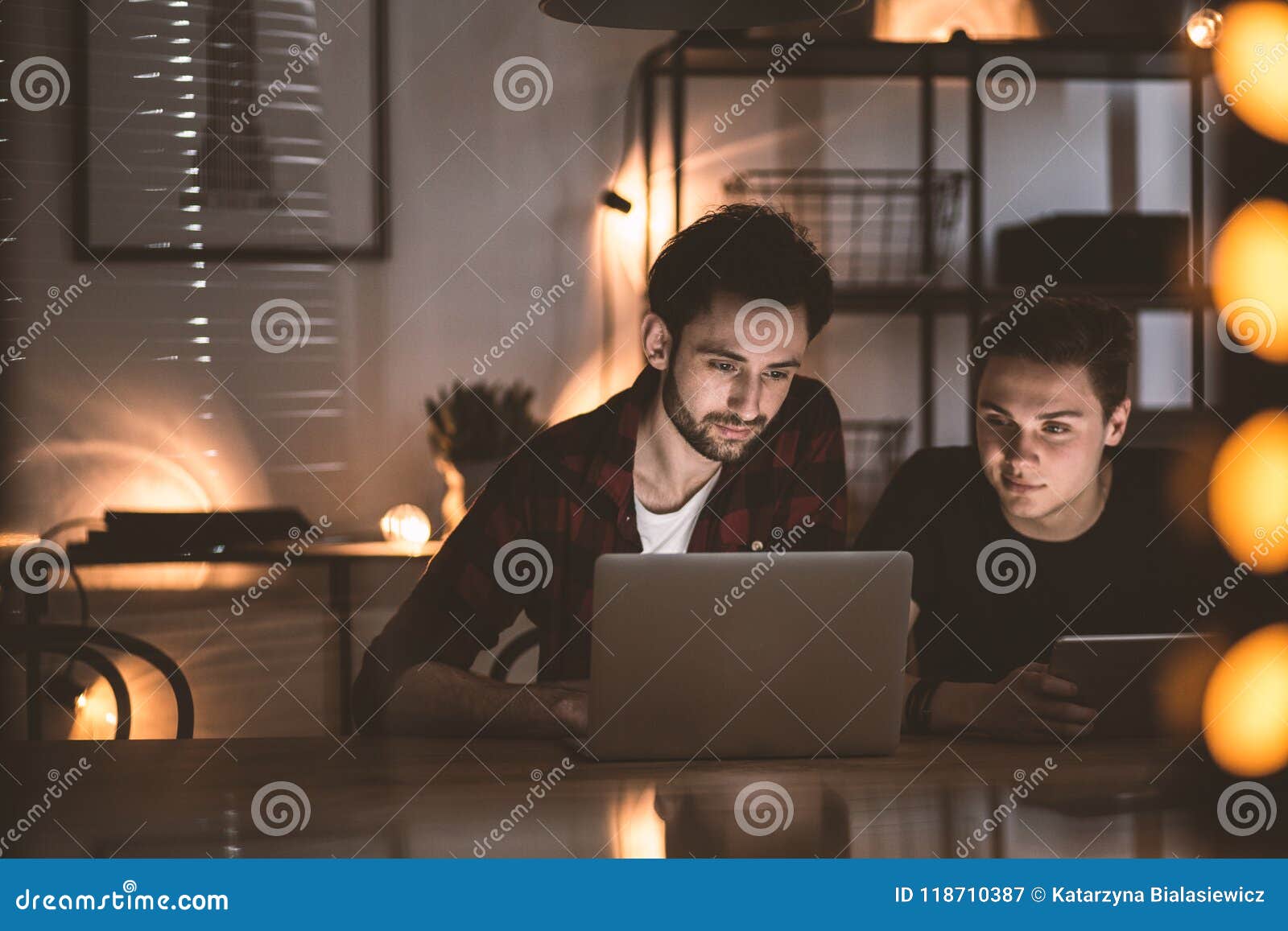 Friends Working at the Computer at Night Surrounded by Lights Stock ...