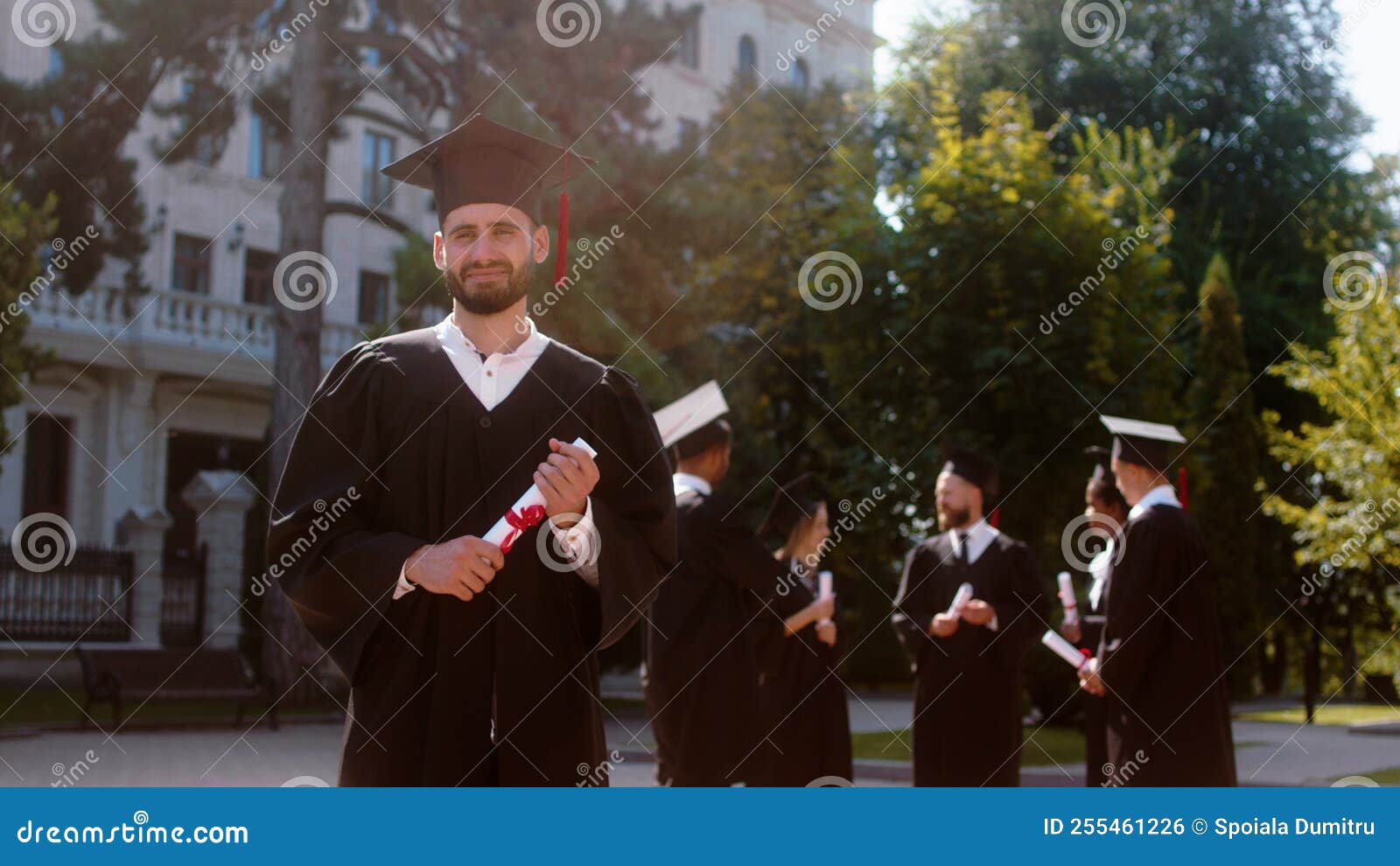 In Front of the Camera Graduate Guy with Graduation Cap Posing in Front ...