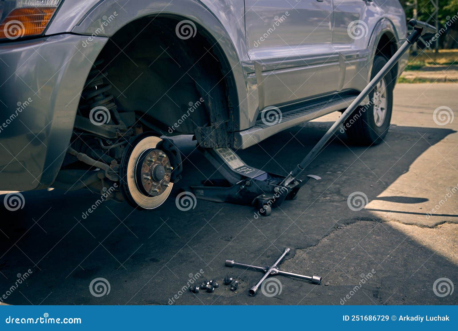 The Front Left Wheel is Dismantled from a Car Which is Propped Up on a ...