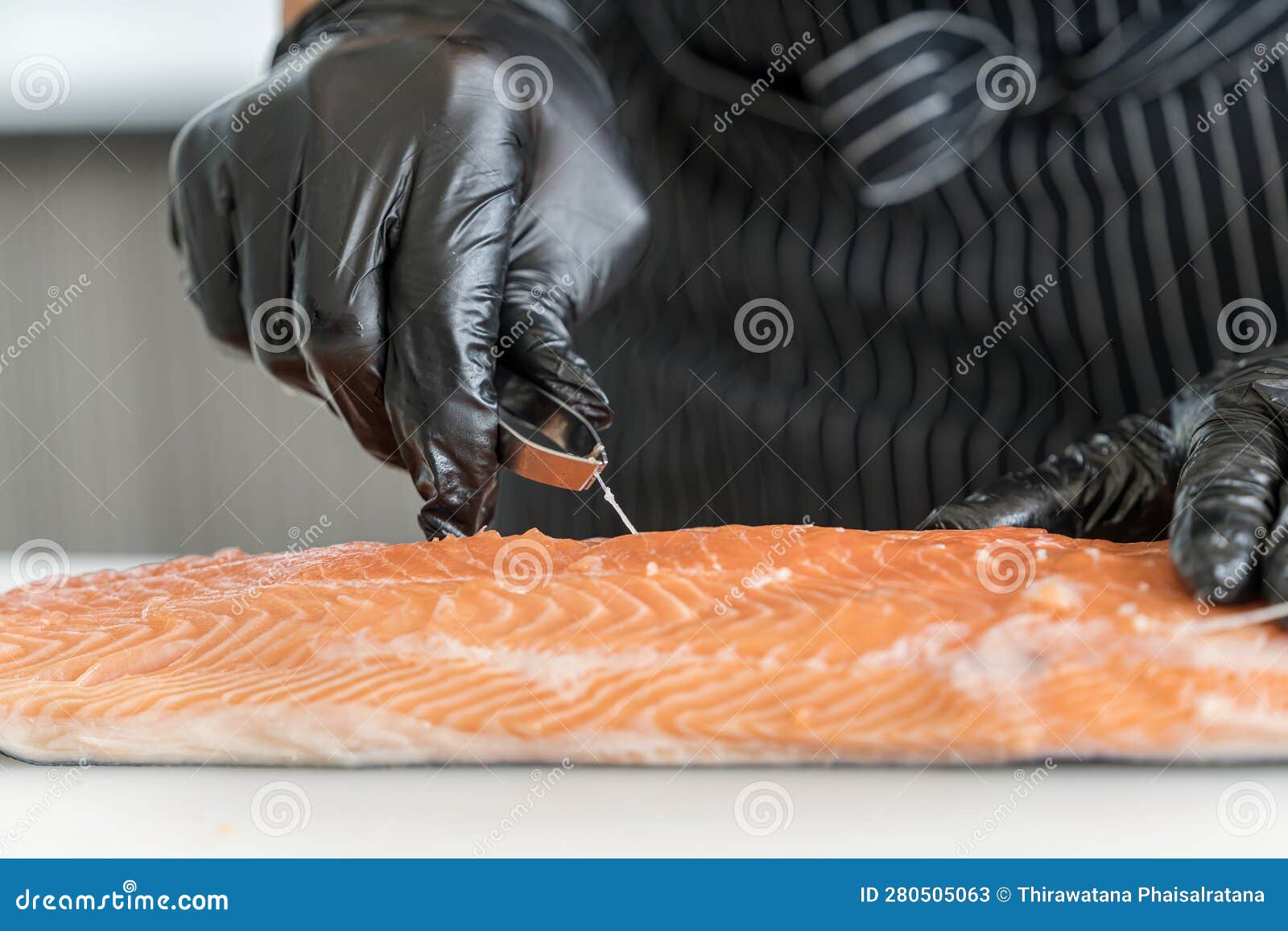 The Front of the Table. Close Up Hand of Chef Pulling Salmon Fish Bone ...