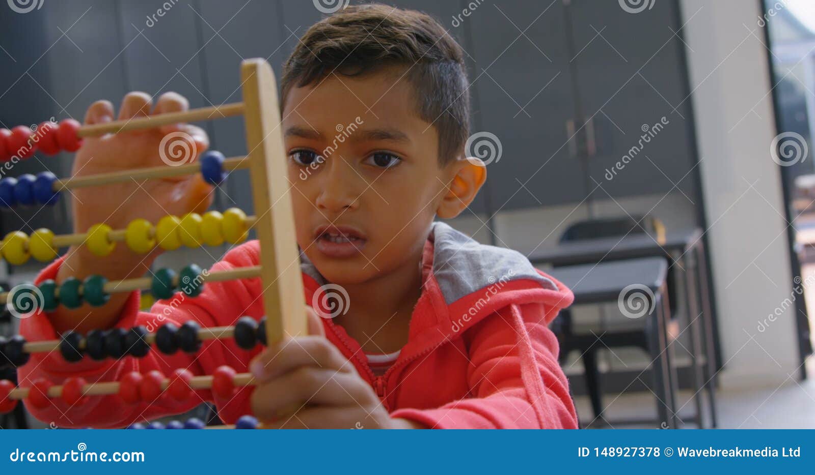 Front View of Asian Schoolboy Solving Math Problem with Abacus at Desk ...