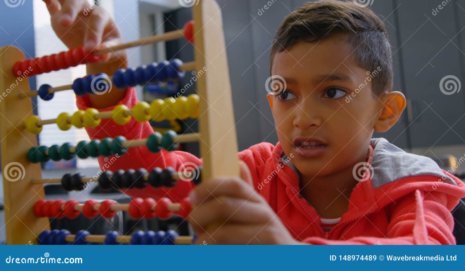 Front View of Asian Schoolboy Solving Math Problem with Abacus at Desk ...