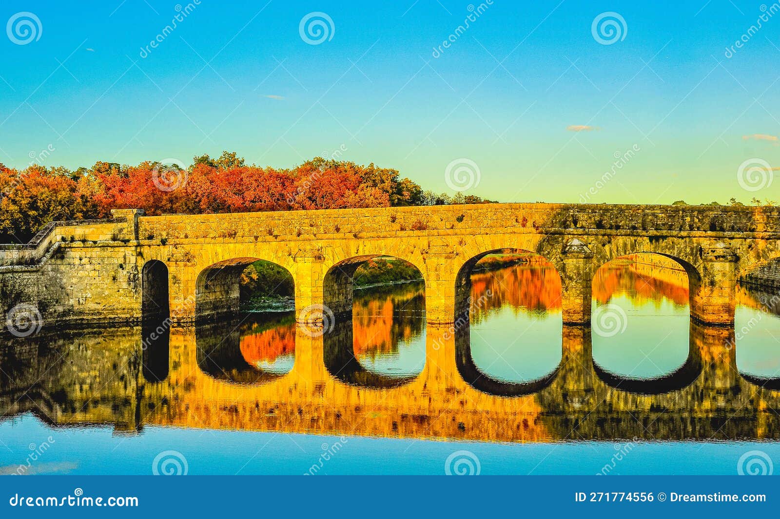 Limestone Bridge, with Six Support Columns Over a Quiet River at Sunset ...