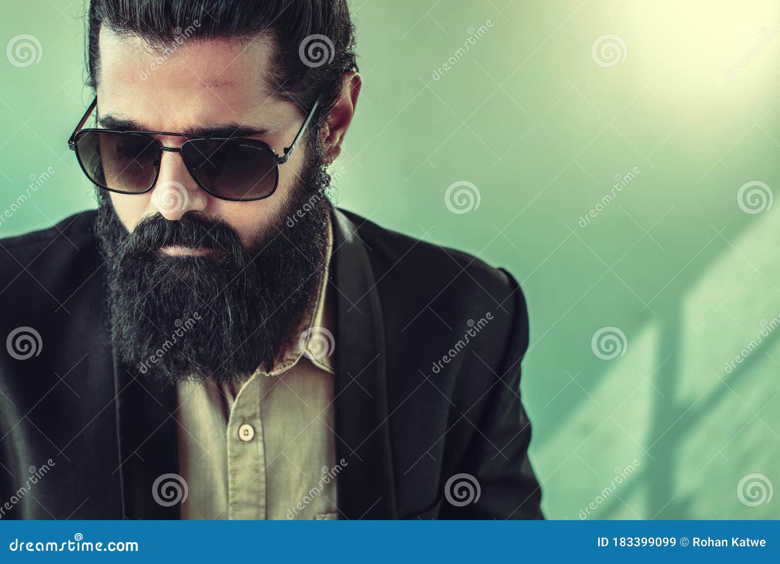 Front View Of Handsome Bearded Man With A Man Bun Hairstyle Posing In