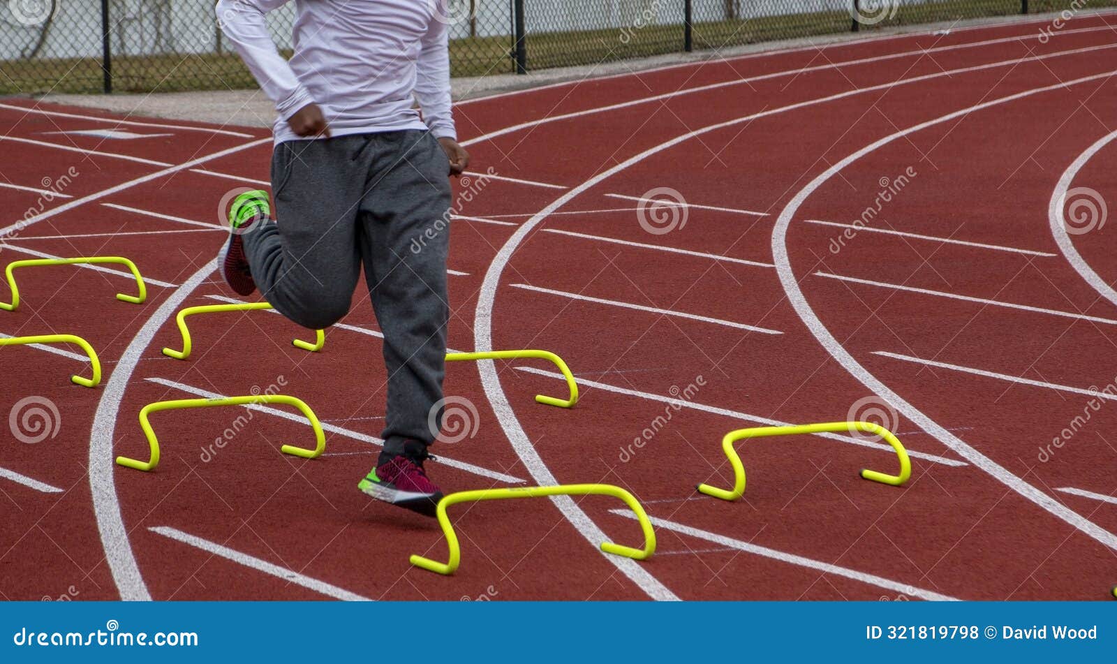 High School Boy Running Over Yellow Mini Hurdles Stock Photo - Image of ...
