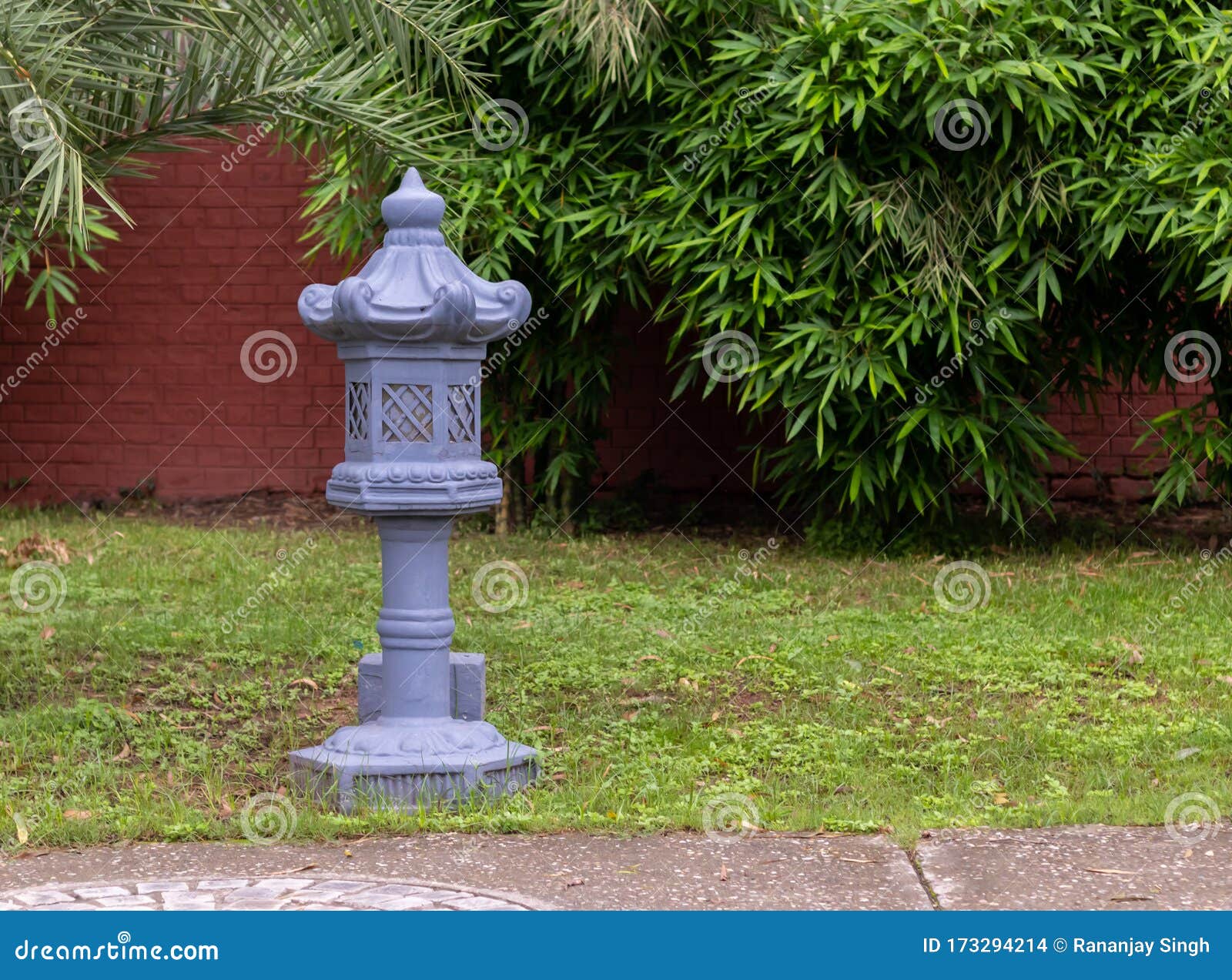 Front View of a Lamp Post with Brick Wall in the Background Covered by ...