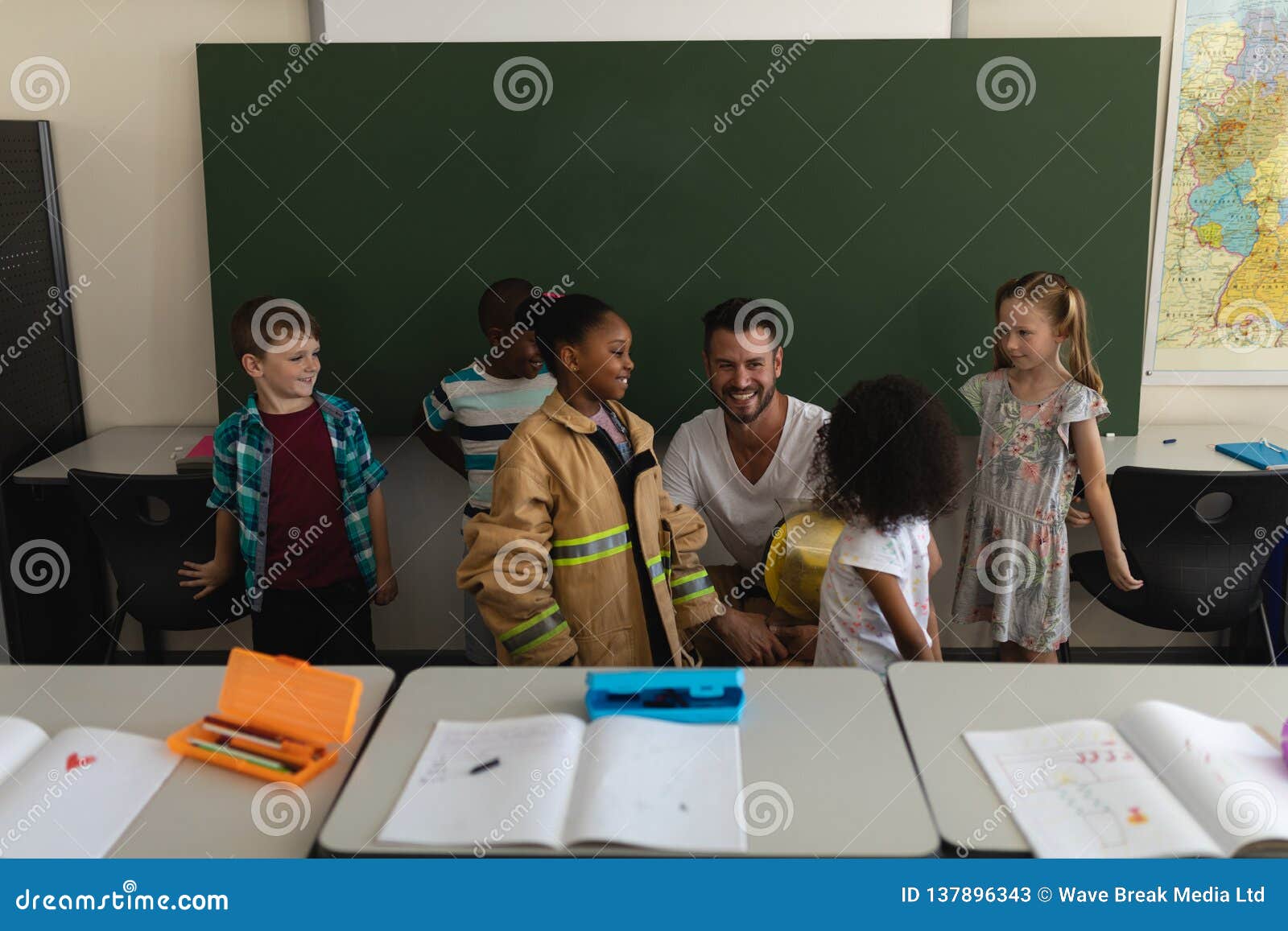 Front View of Male Firefighter Teaching Schoolkids about Fire Safety in ...
