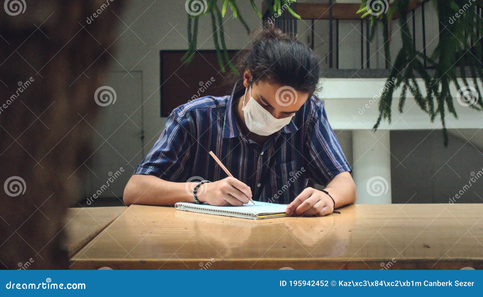 Front View of a Masked Young University Student Studying in the Library ...