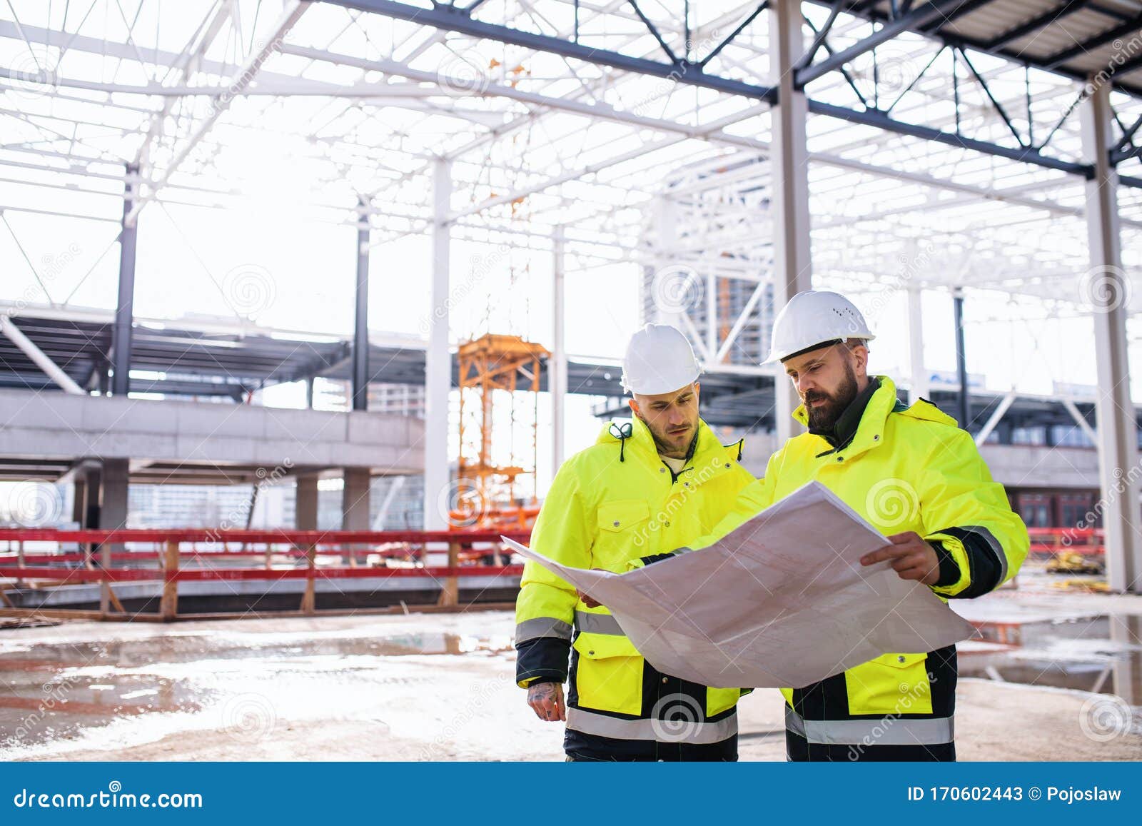 Men Engineers Standing Outdoors on Construction Site, Holding ...