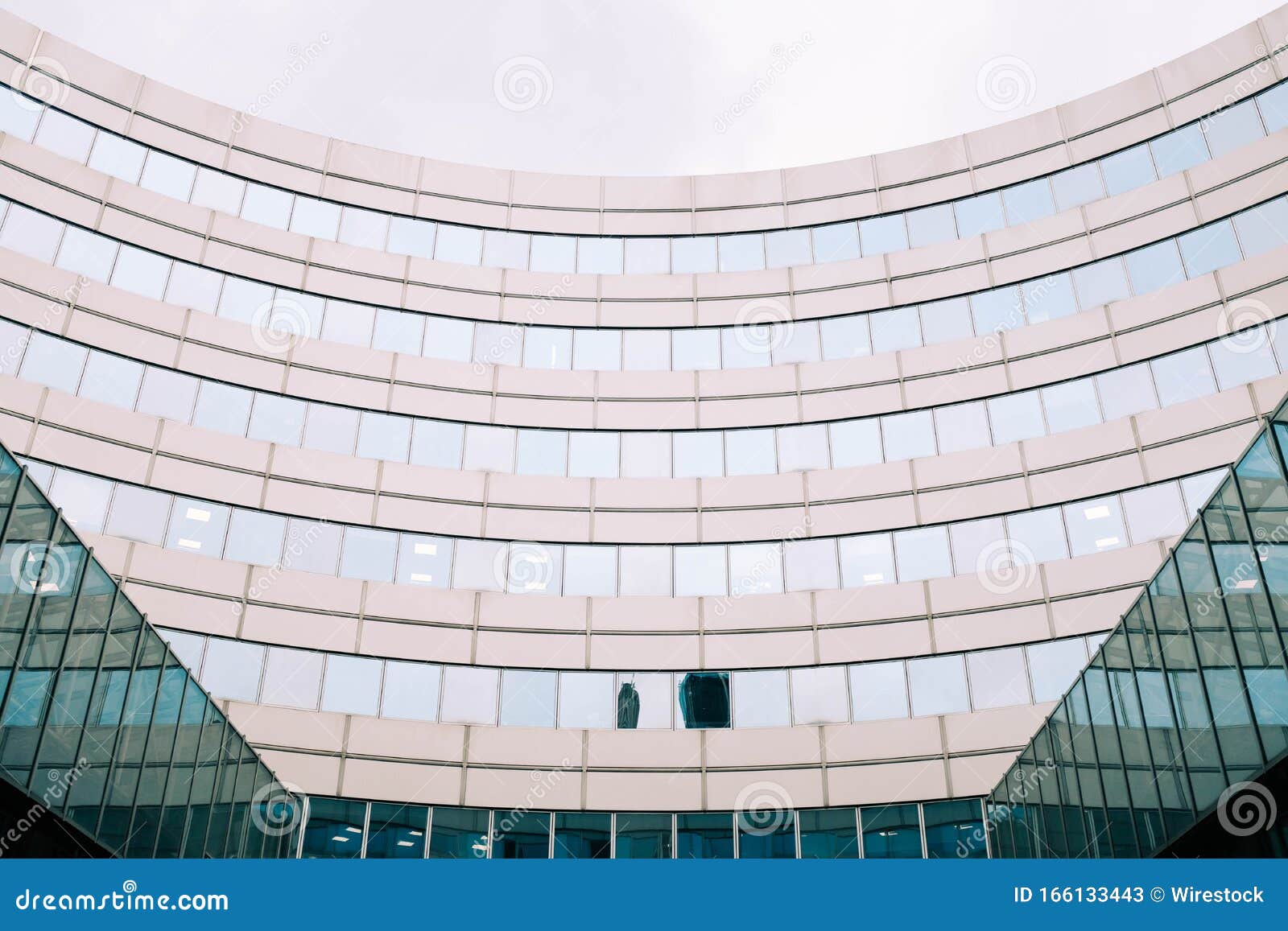 Front View of a Modern Skyscraper with Pink and Blue Windows Under a ...