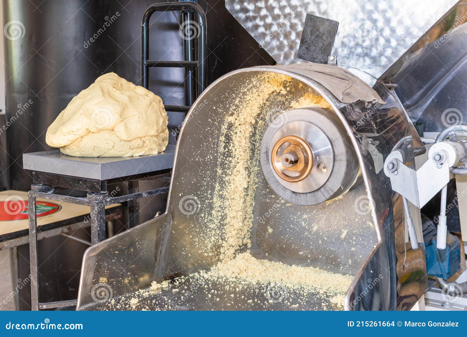 Front View of a Nixtamal Mill while a Man Takes Out the Dough that is ...