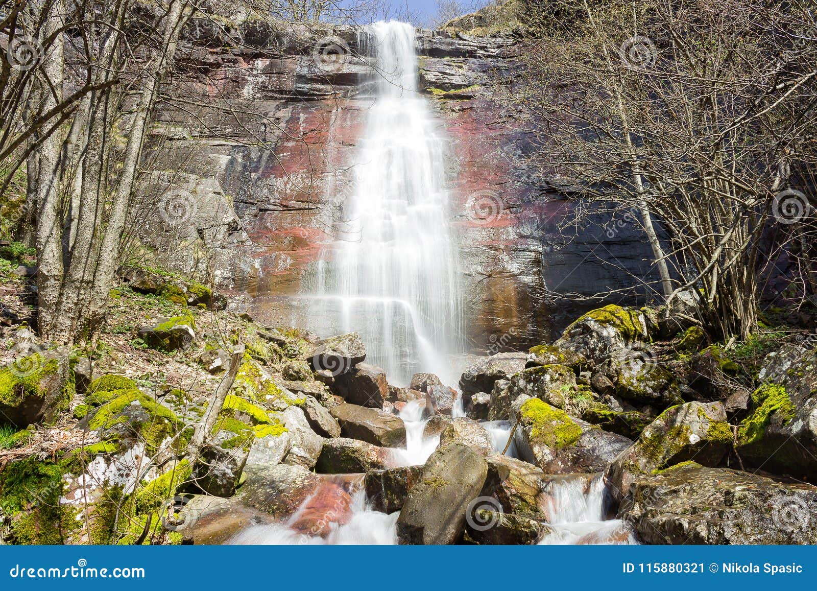 Powerful, Sunlit Waterfall Streaming Down the Red Cliff Stock Image ...