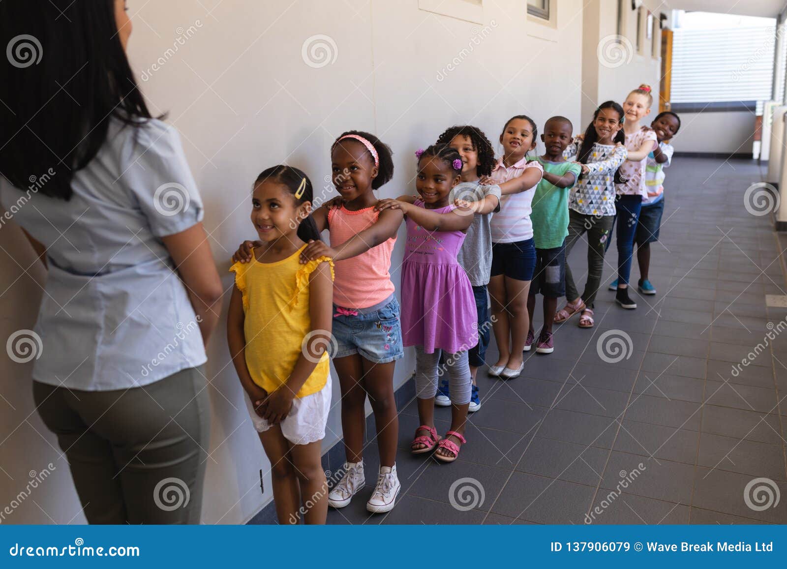 Front View of Schoolkids with Teacher Standing in Row with Their Hands ...
