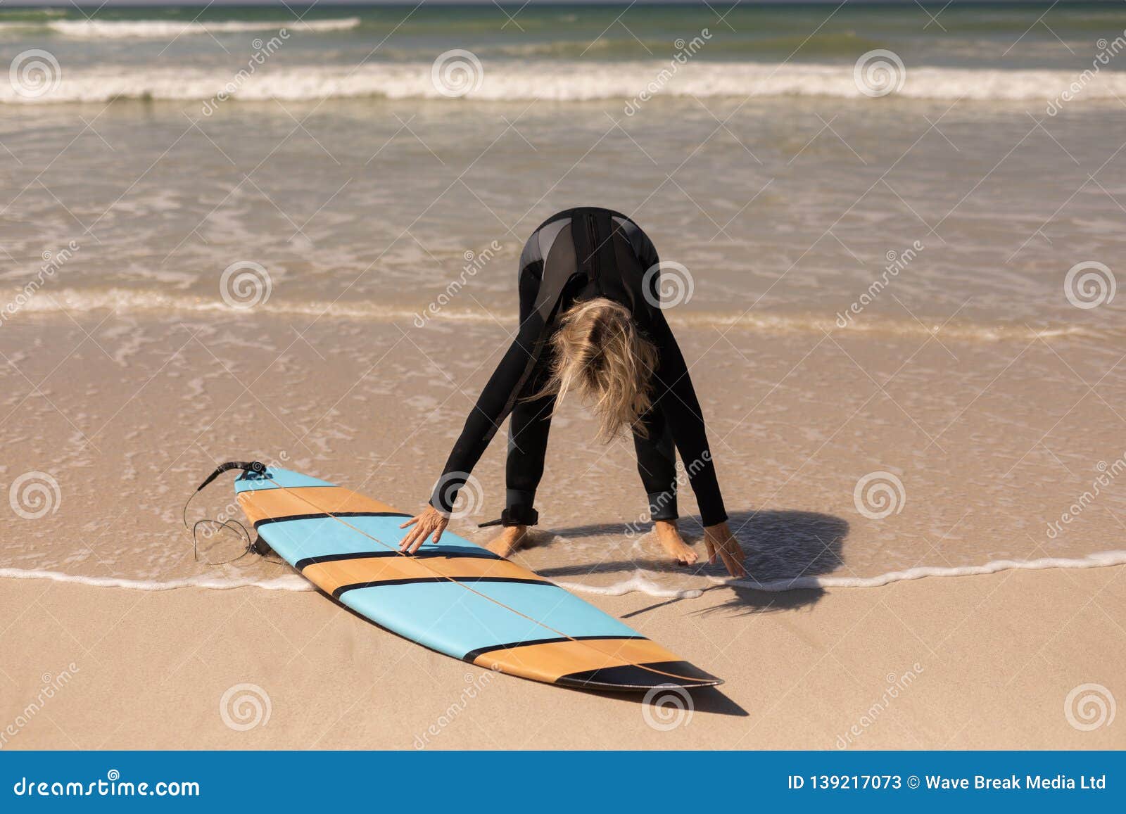 Front View of Senior Female Surfer with Surfboard Exercising on the ...