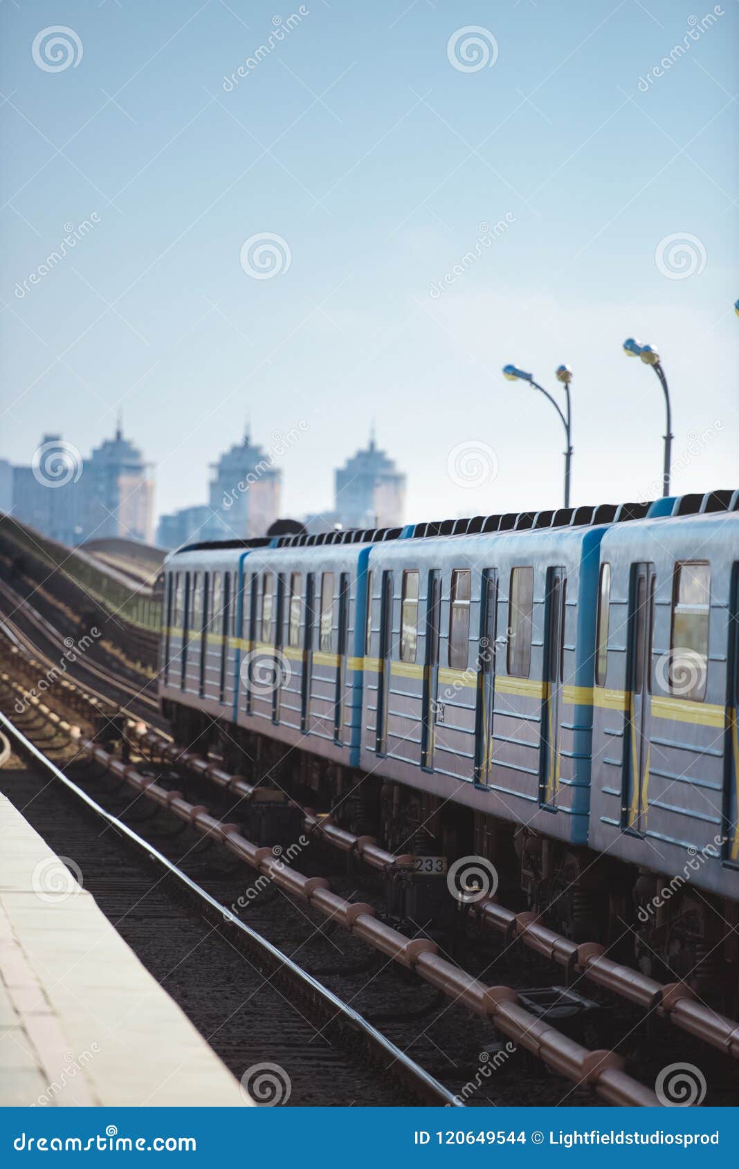 Front View of Train at Outdoor Subway Station with Buildings Stock ...