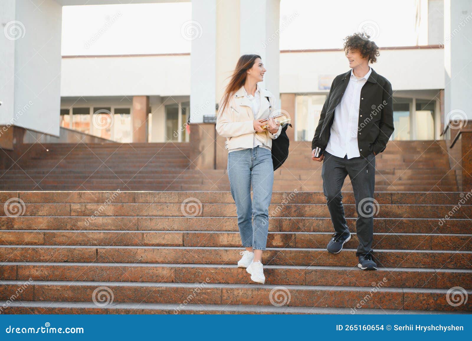Front View of Two Students Walking and Talking in an University Campus ...