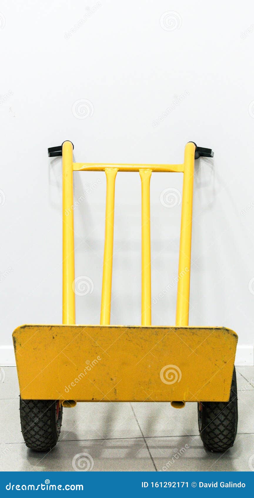 Front View of Yellow Manual Transport Trolley Resting on Wall Stock ...