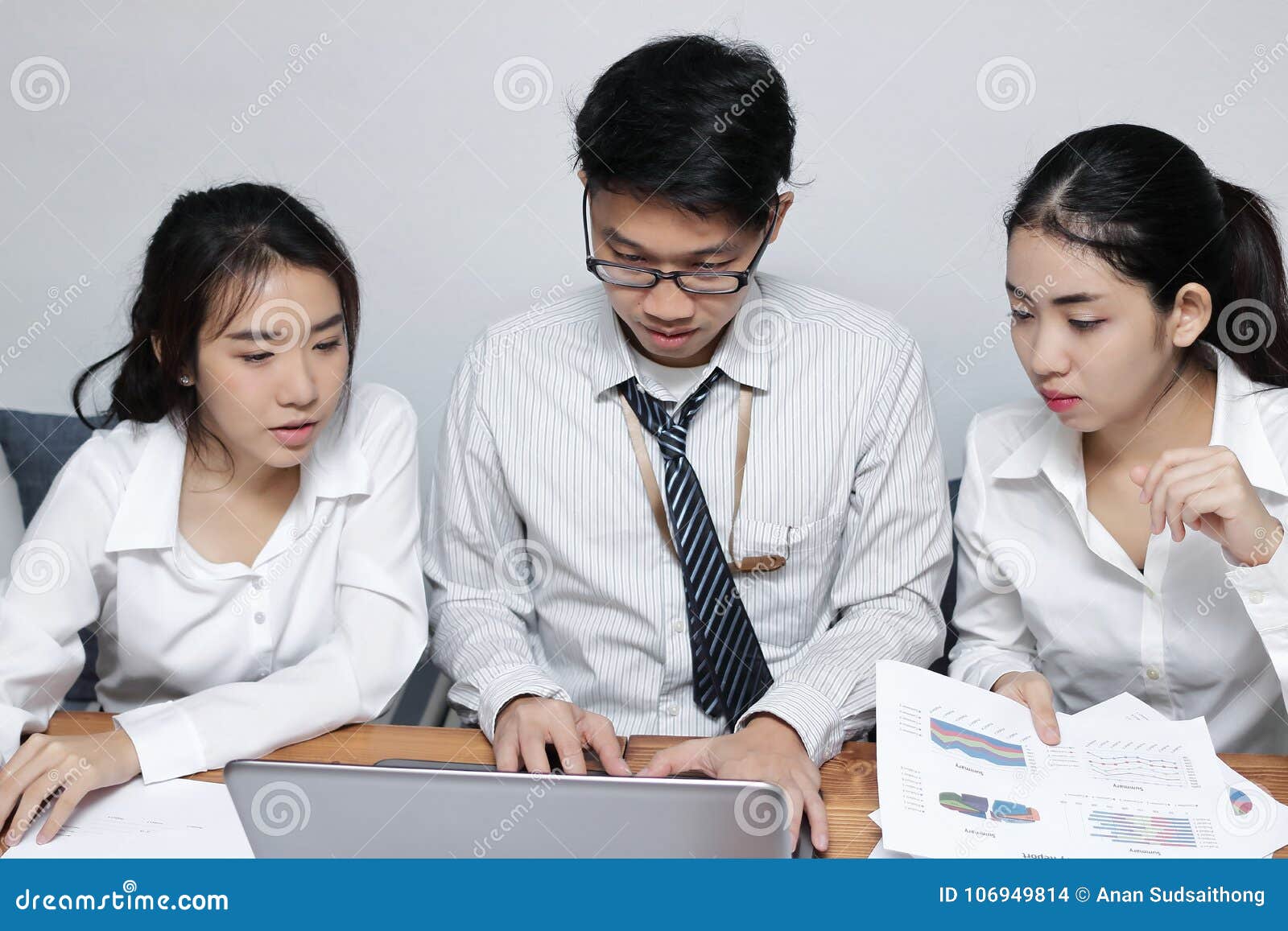 Front View of Young Asian Business People Working Together on a Laptop ...