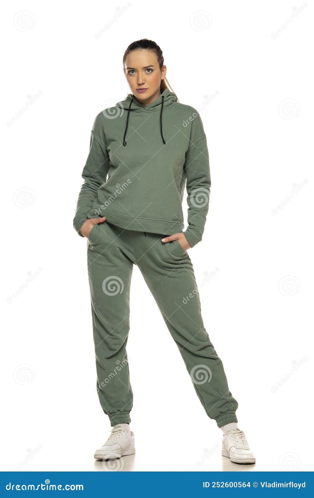 Front View of a Young Woman in a Green Tracksuit Posing To a White ...