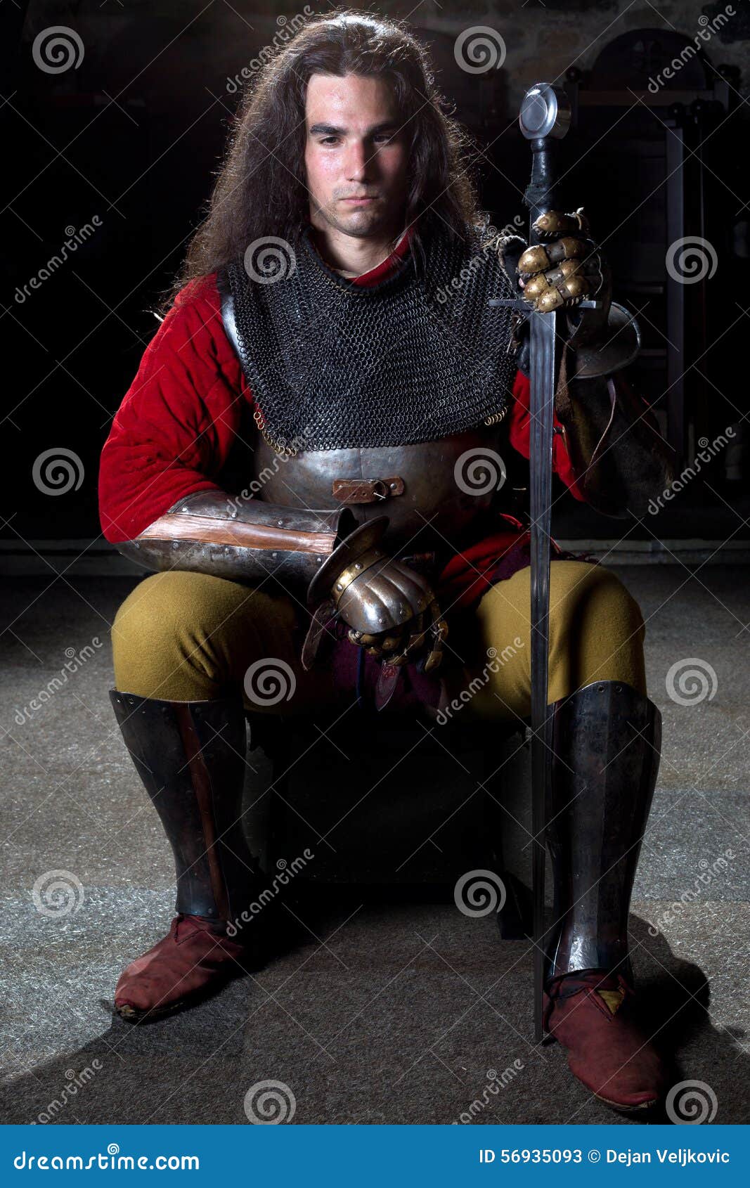 Frontal View of Knight with Sword Sitting Against Stone Wall Stock ...