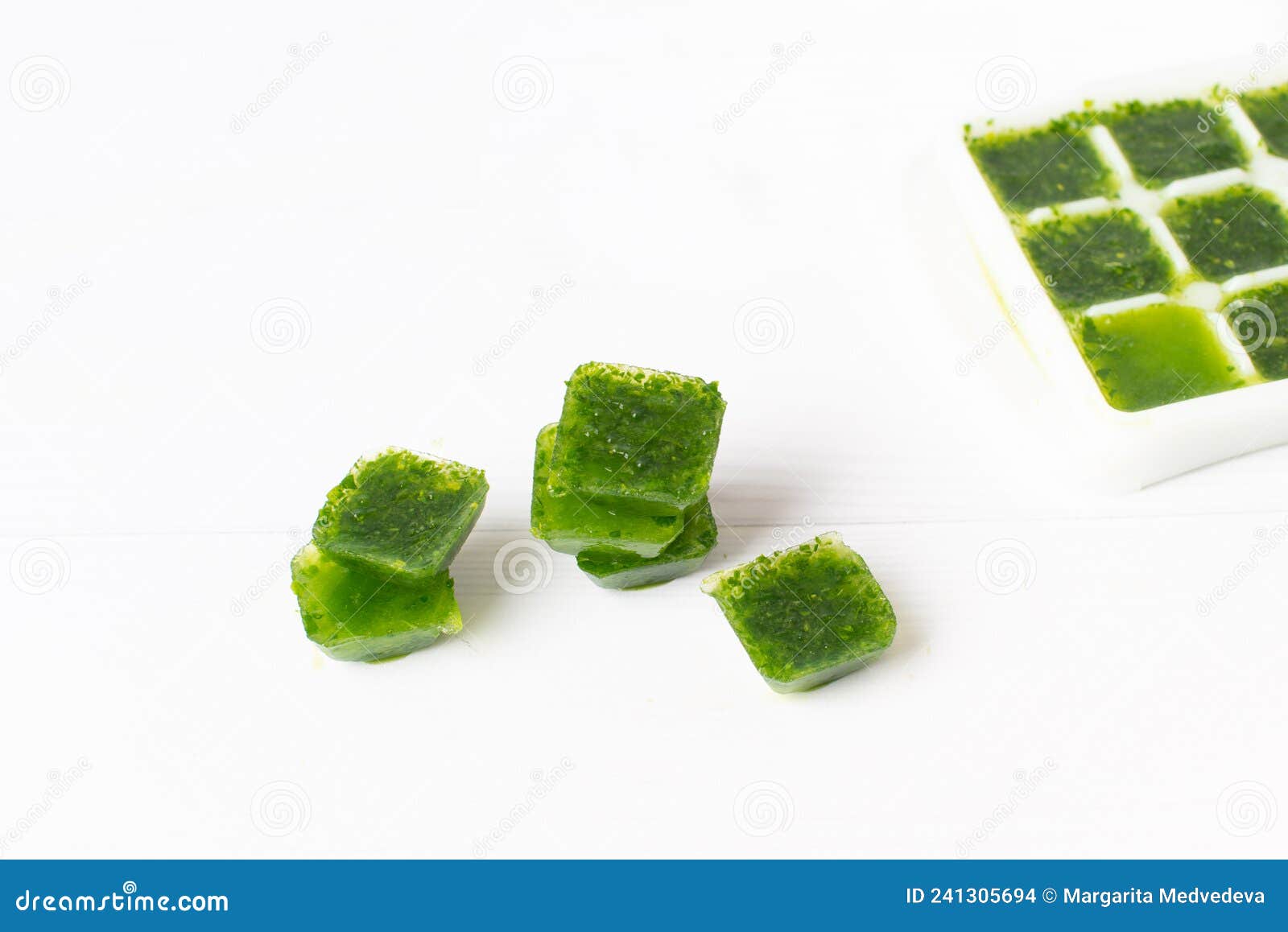 Frozen Basil Leaves in Ice Cubes with Fresh Basil on a Table. Frozen ...