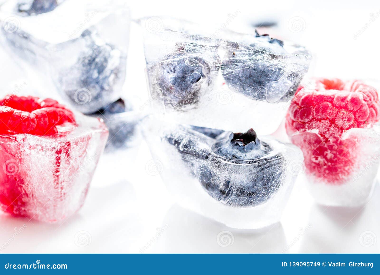 Frozen Blueberry and Raspberry in Ice Cubes on White Background Stock ...