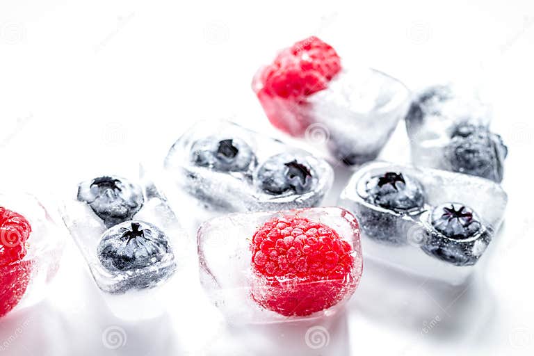 Frozen Blueberry and Raspberry in Ice Cubes on White Background Stock ...