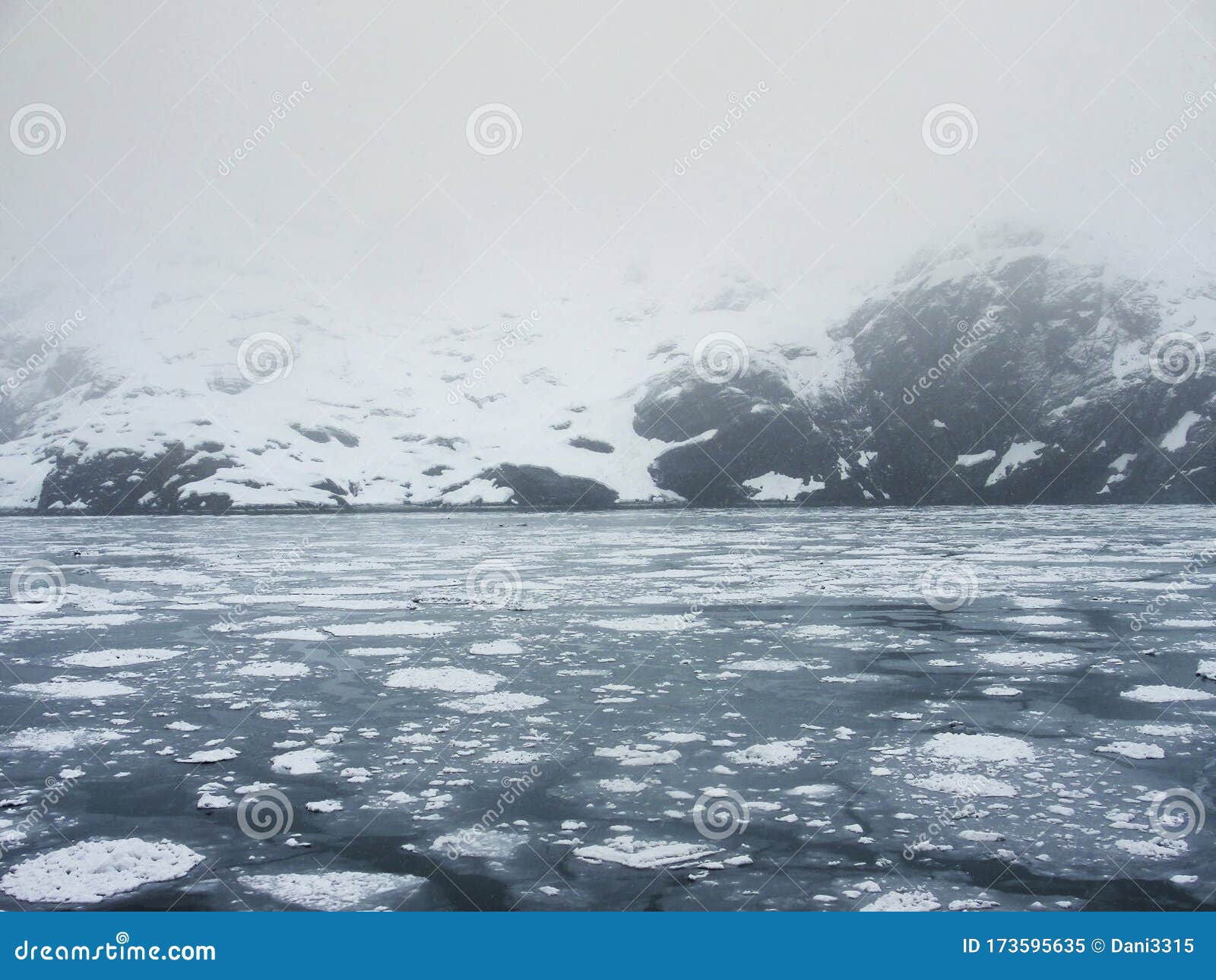 Frozen Water Surface and Snow Capped Mountains on the Coastline of ...