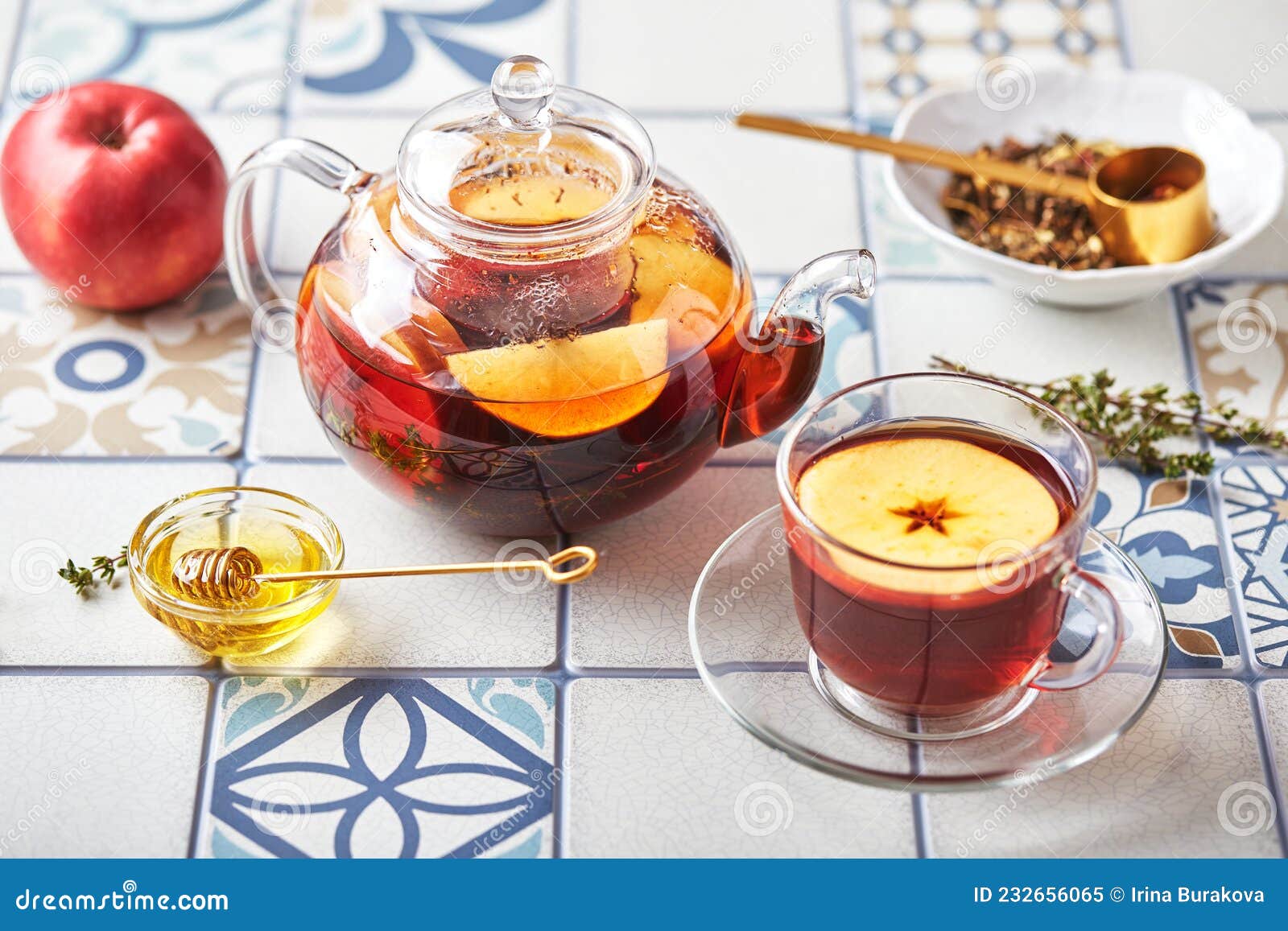 Fruit Tea with Apples and Thyme in Glass Teapot and Cup on Table Made ...